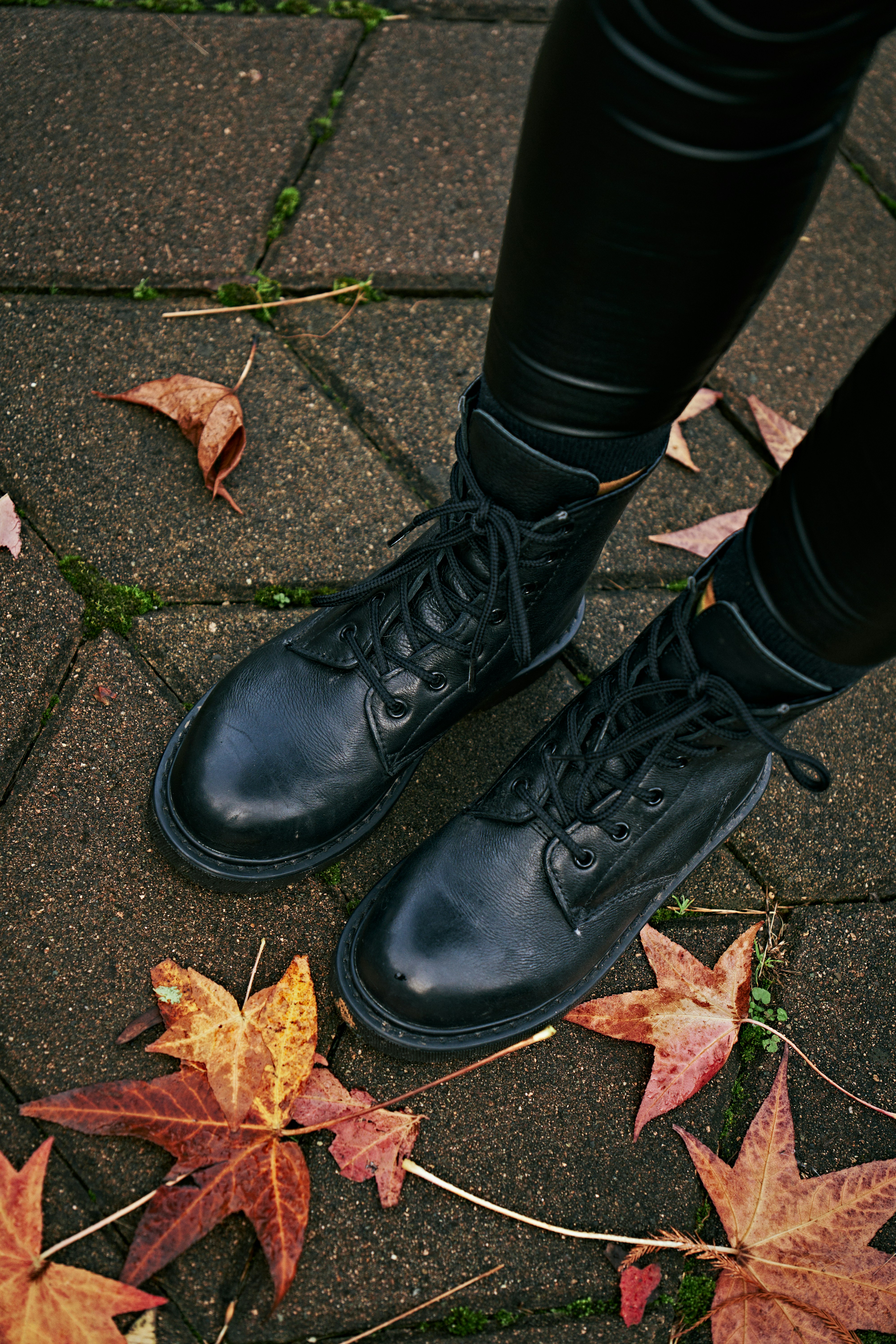 Midnight Leather Boots on a Leaf-Spotted Cobblestone Path