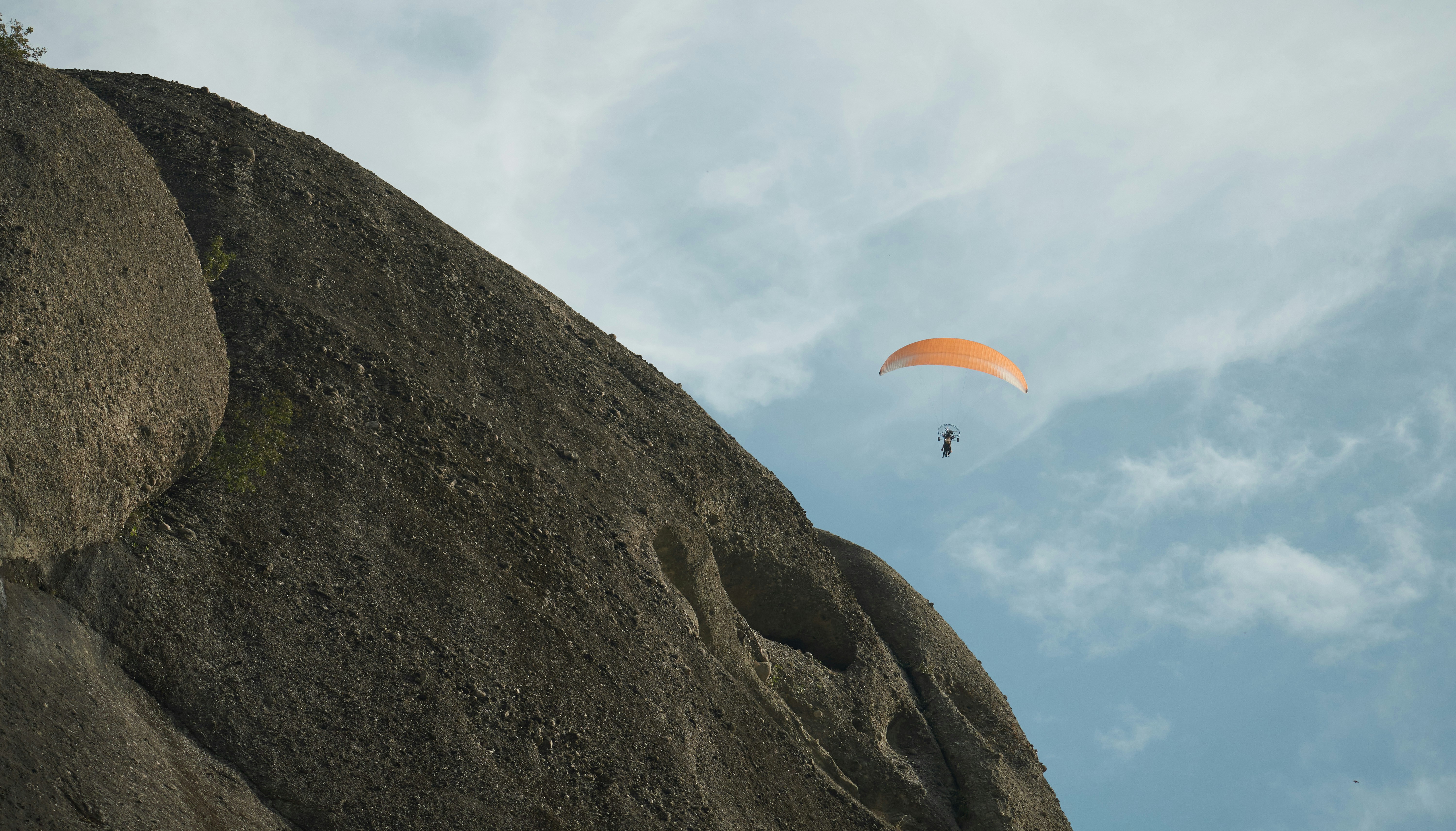 A paraglider is flying over a rocky cliff photo – Free Meteora Image on ...