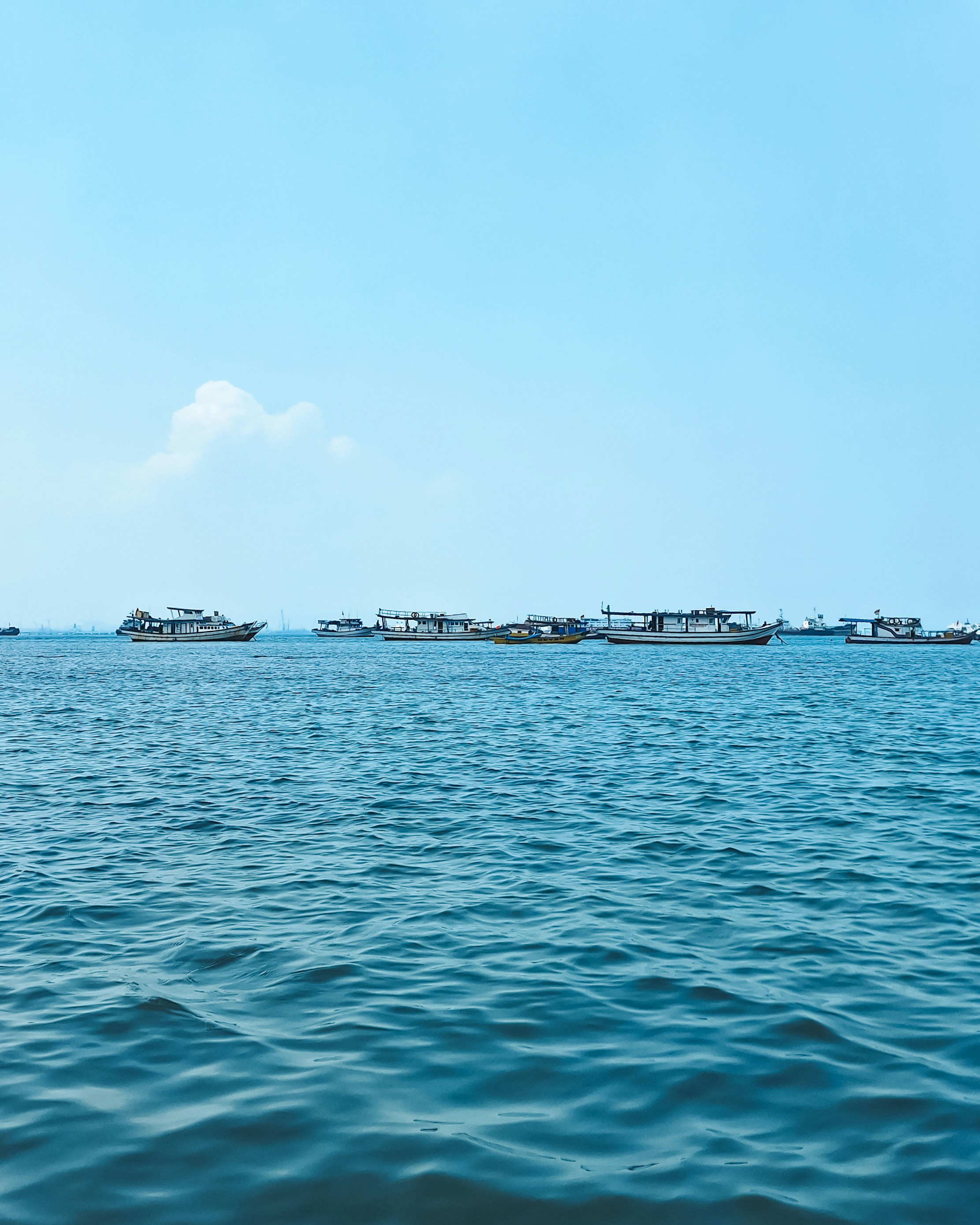 a group of boats floating on top of a large body of water