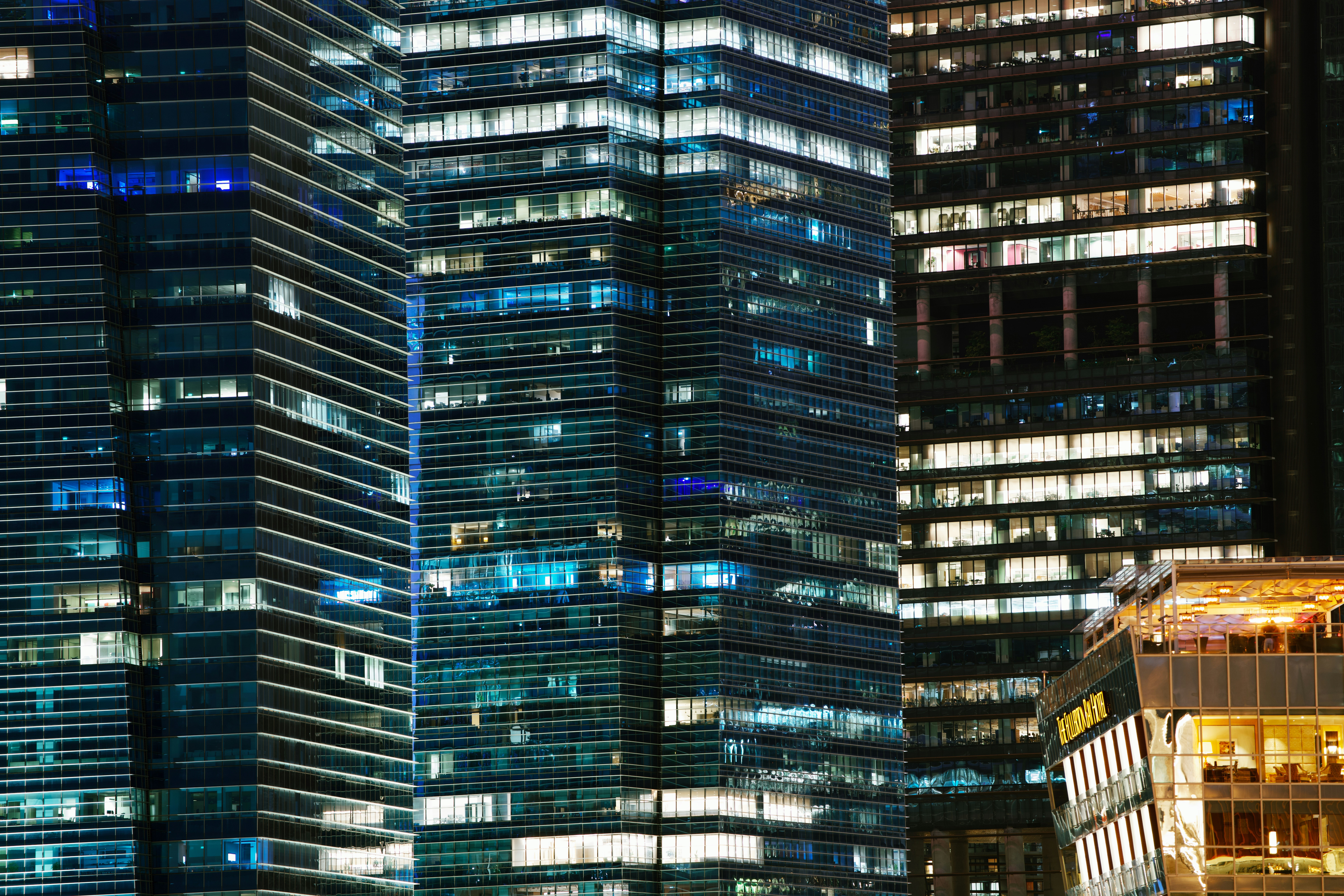 A group of tall buildings lit up at night photo – Free Grey Image on ...