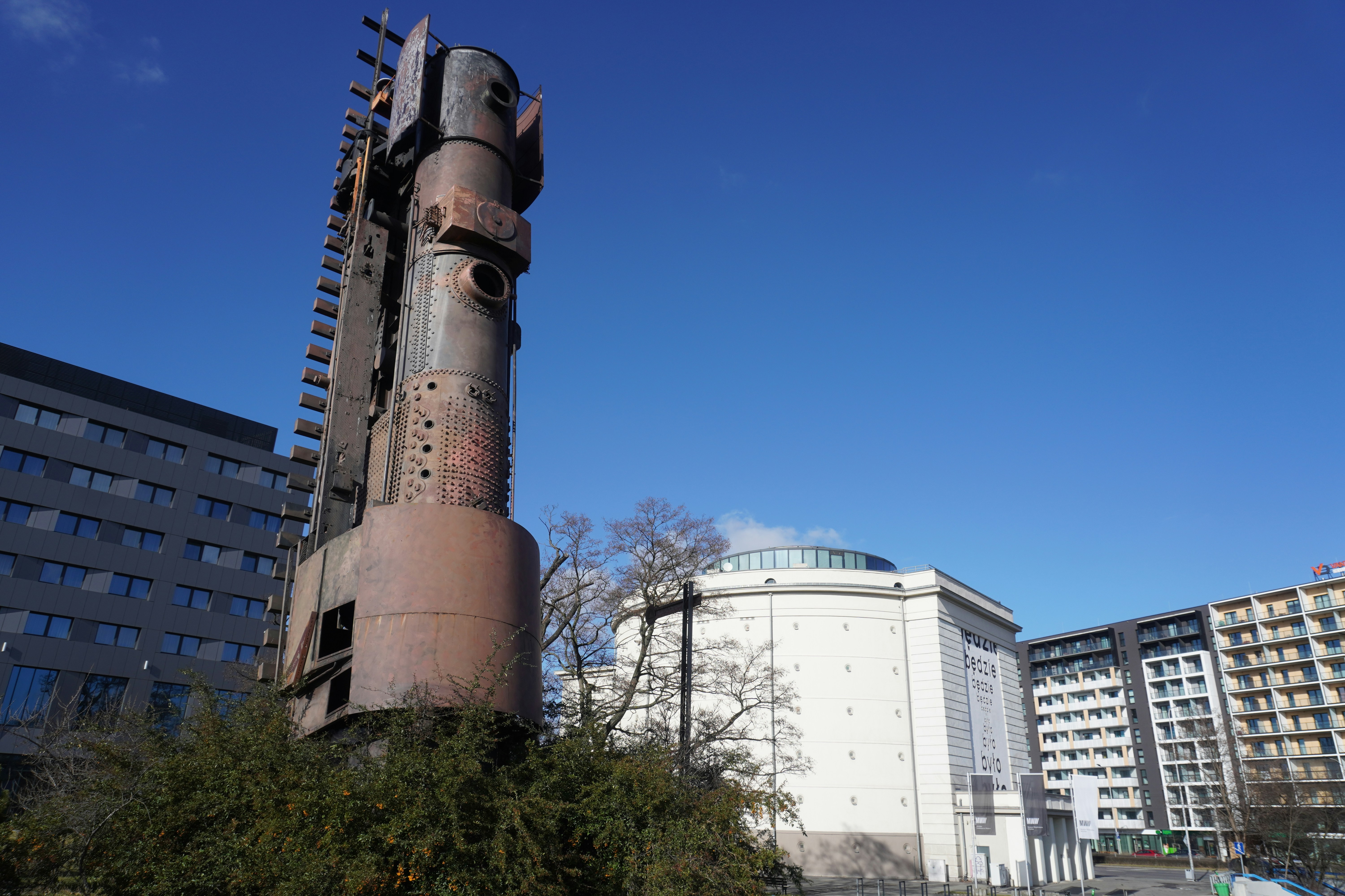 Rust Tower Rising: Industrial Monolith Against a Modern Skyline