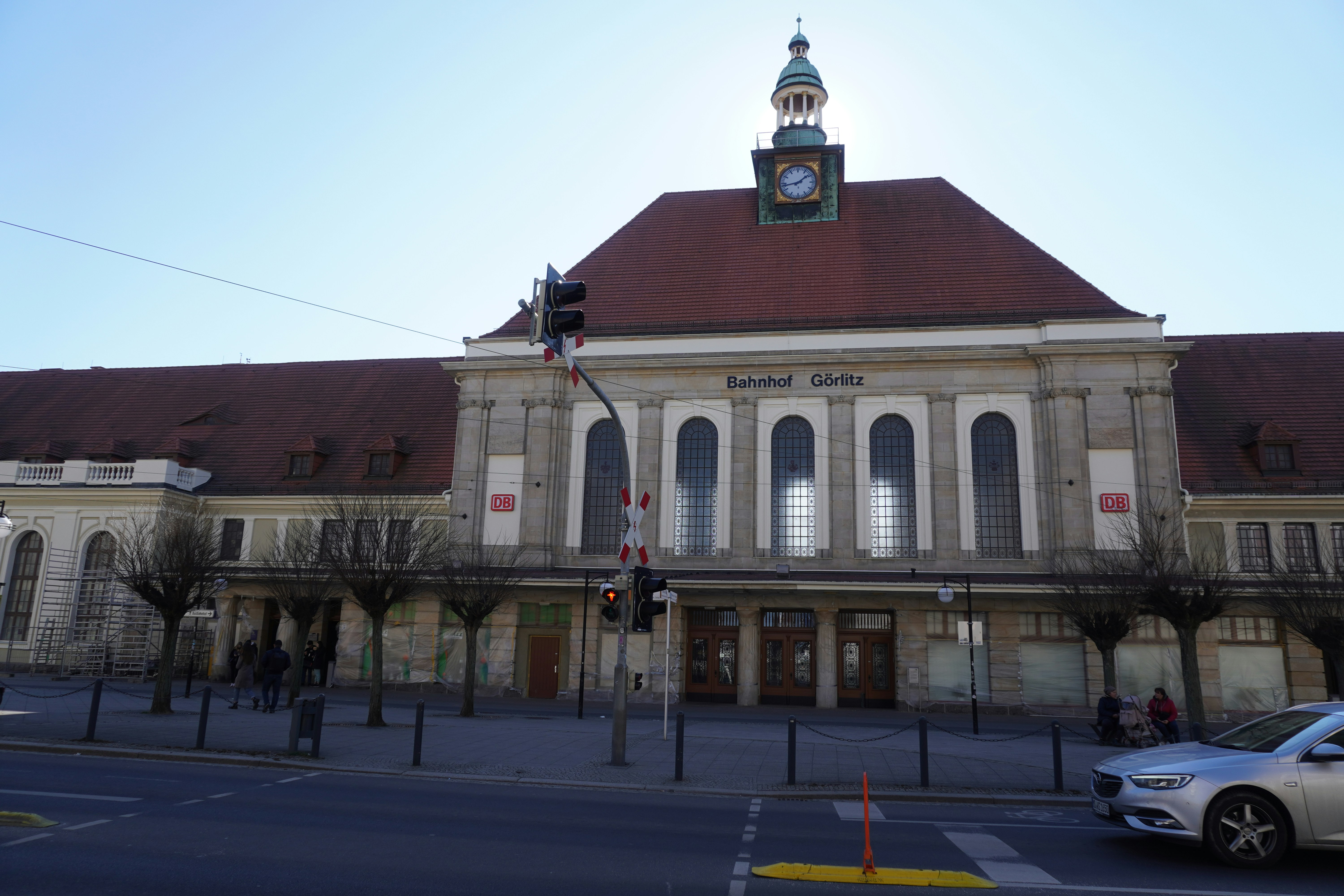 Grand building with a prominent clock tower and arched windows under a red-tiled roof.