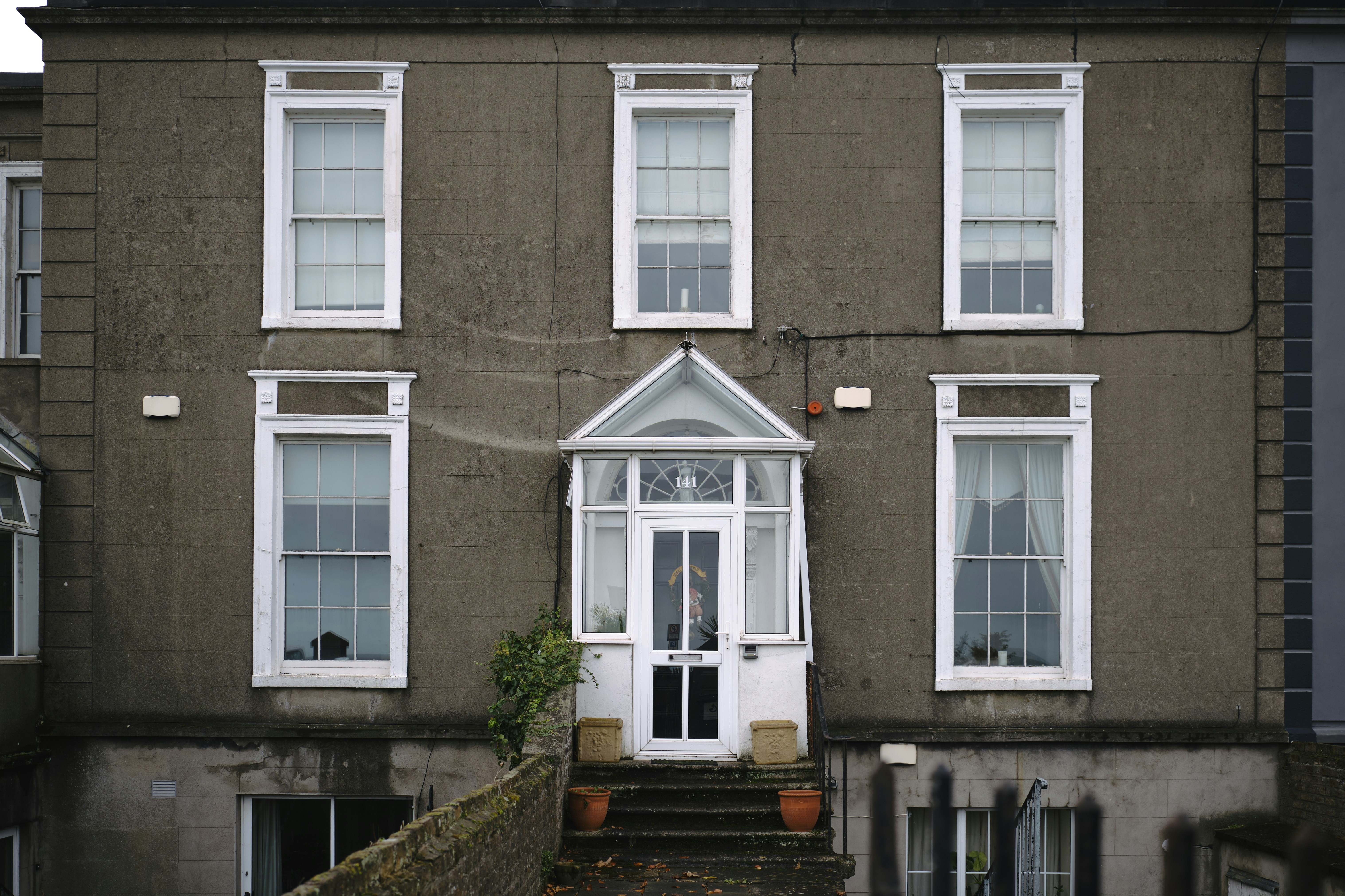 A large brown building with white windows and a white door photo – Free ...