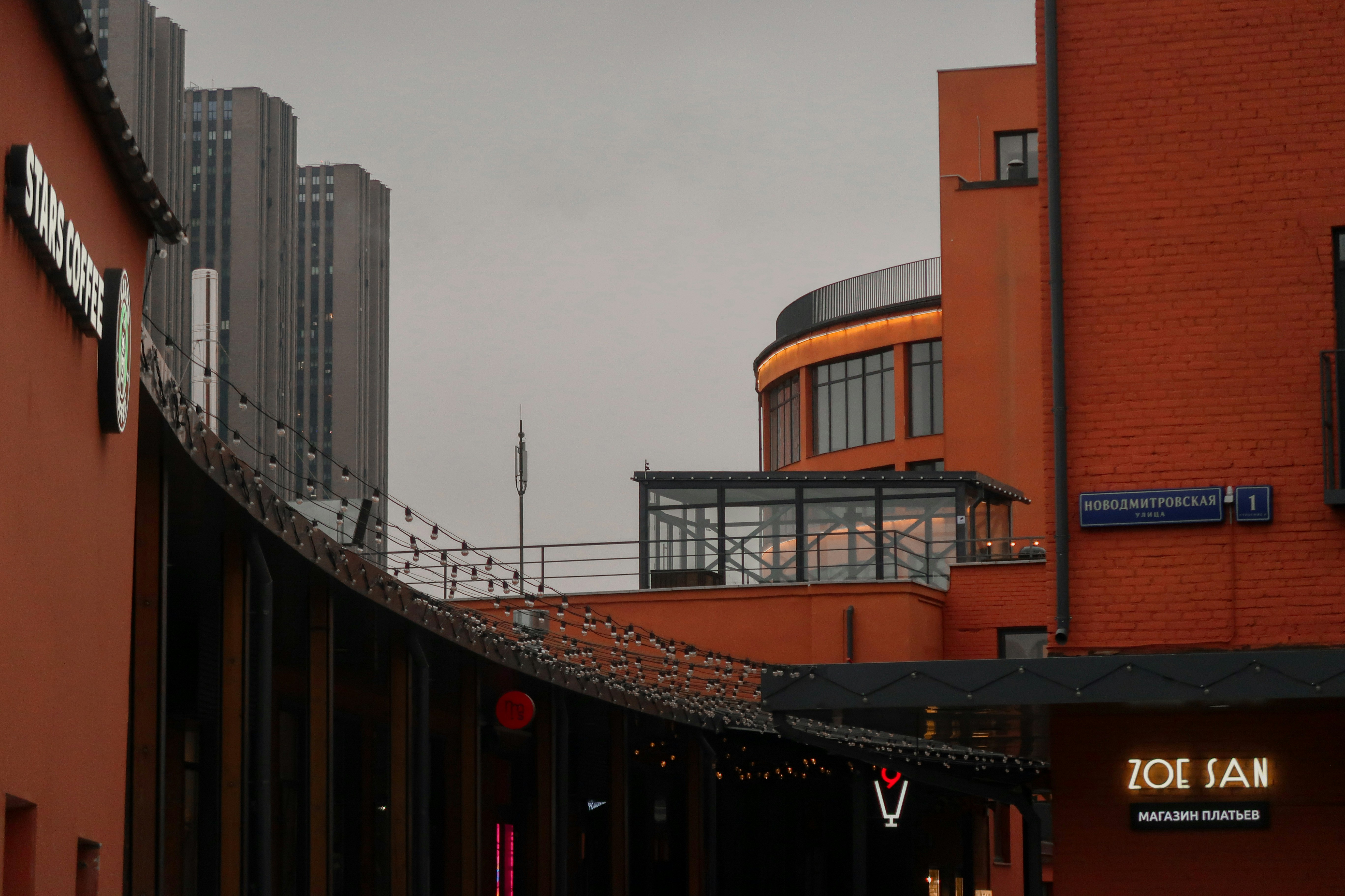 Dusk Arcades: Brick Facades and a Curved Glass Corner