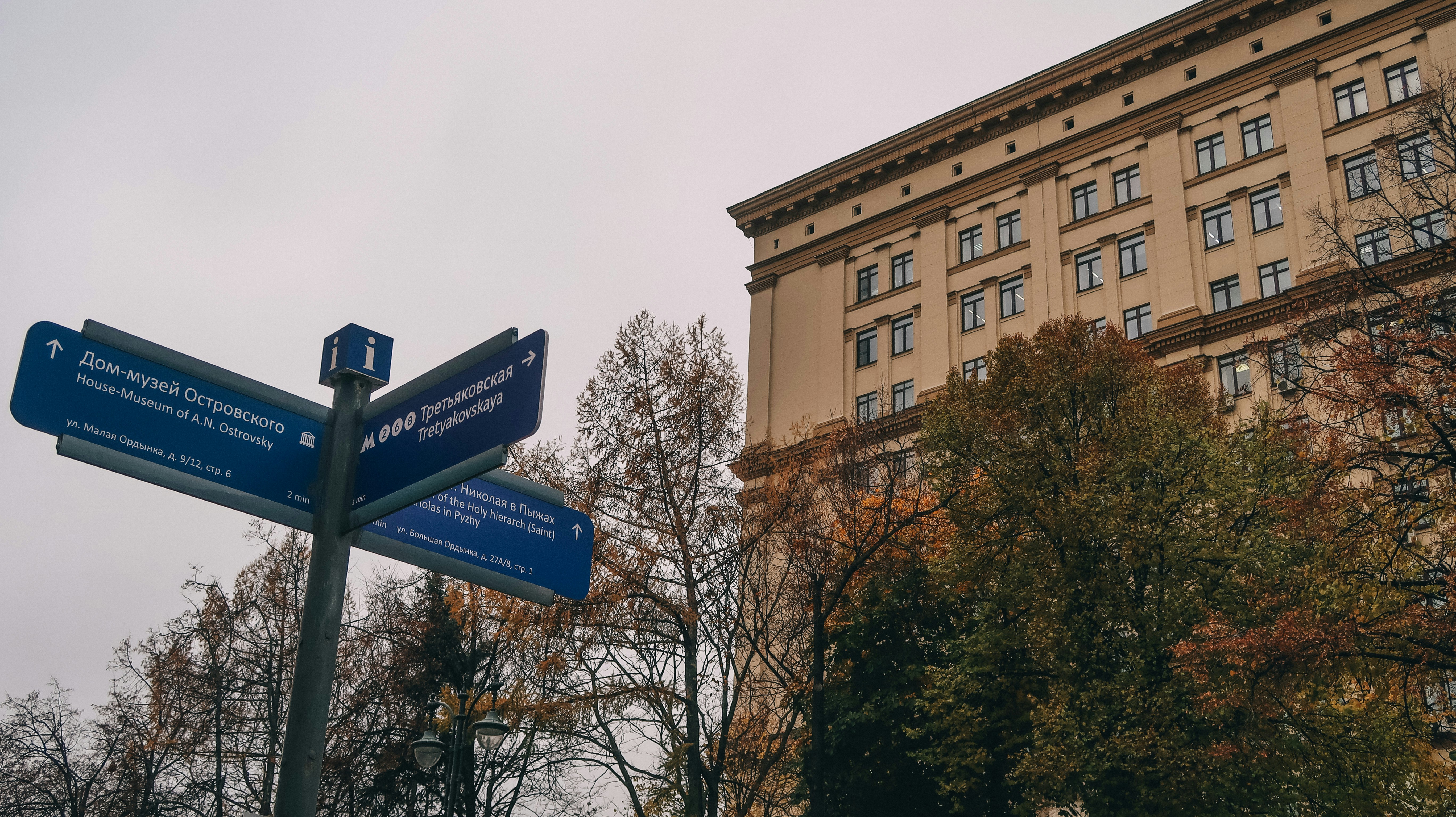 Blue Signpost Against a Cityscape in Autumn