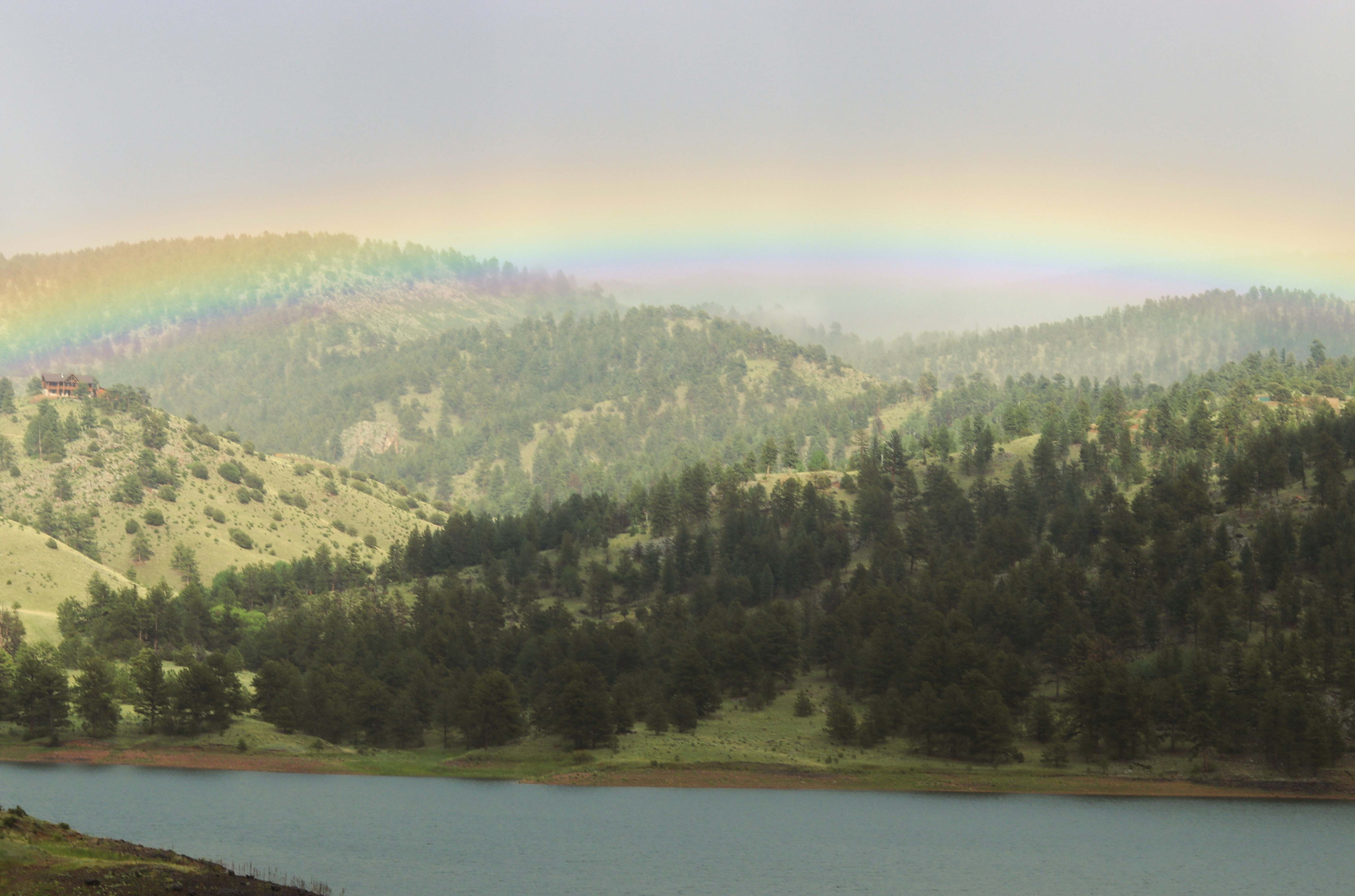 A rainbow in the sky over a lake and mountains photo – Free Colorado ...