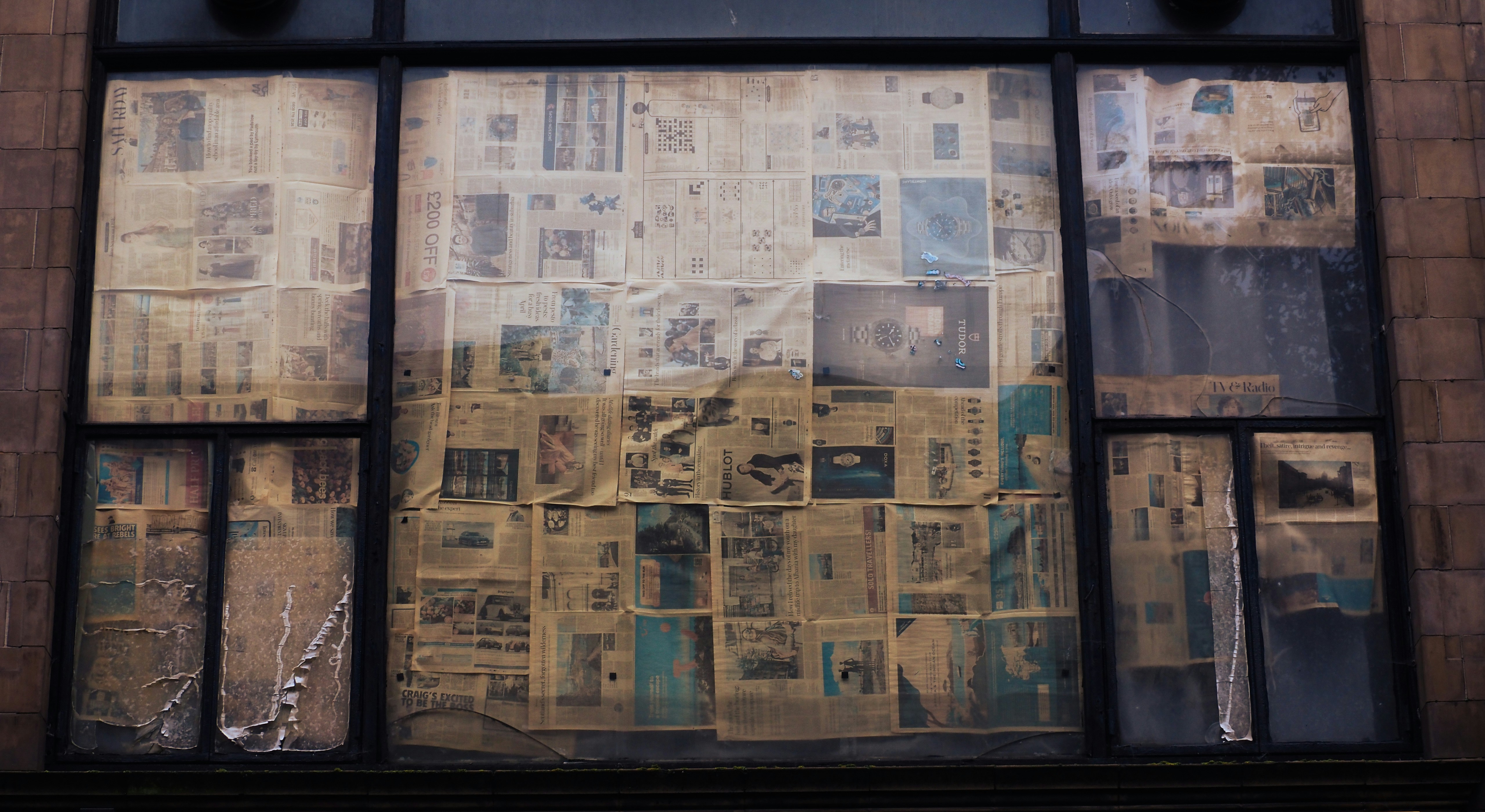 A window with a bunch of newspapers on it photo – Free Human Image on ...