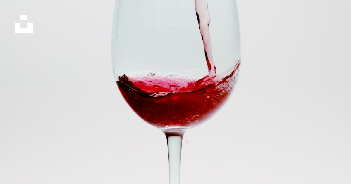 A Wine Glass Filled With Red Wine Being Poured Into It Photo Free Glass Image On Unsplash