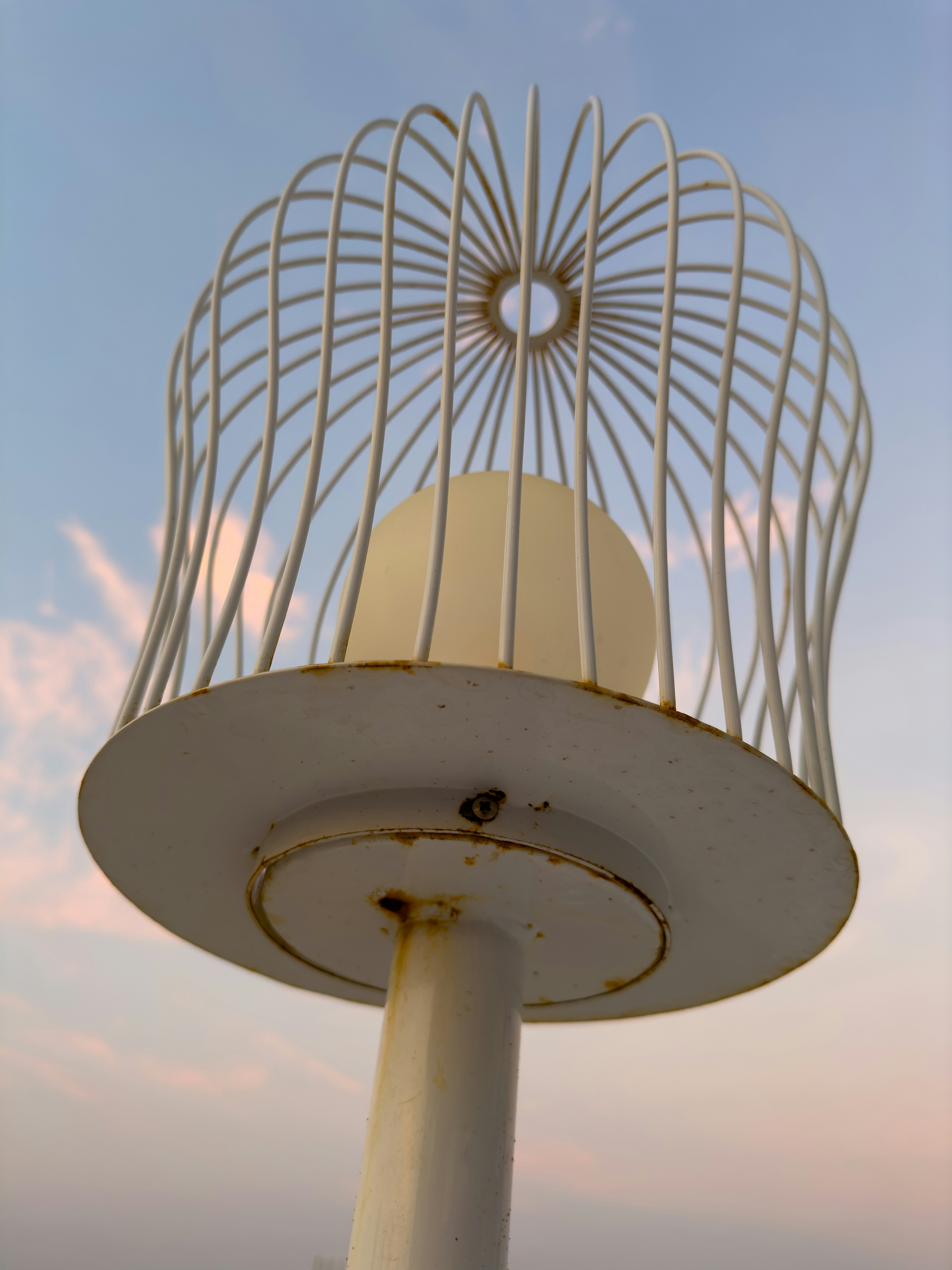 Dusk Cage: Geometry of a Rusted Beacon Against a Soft Sunset