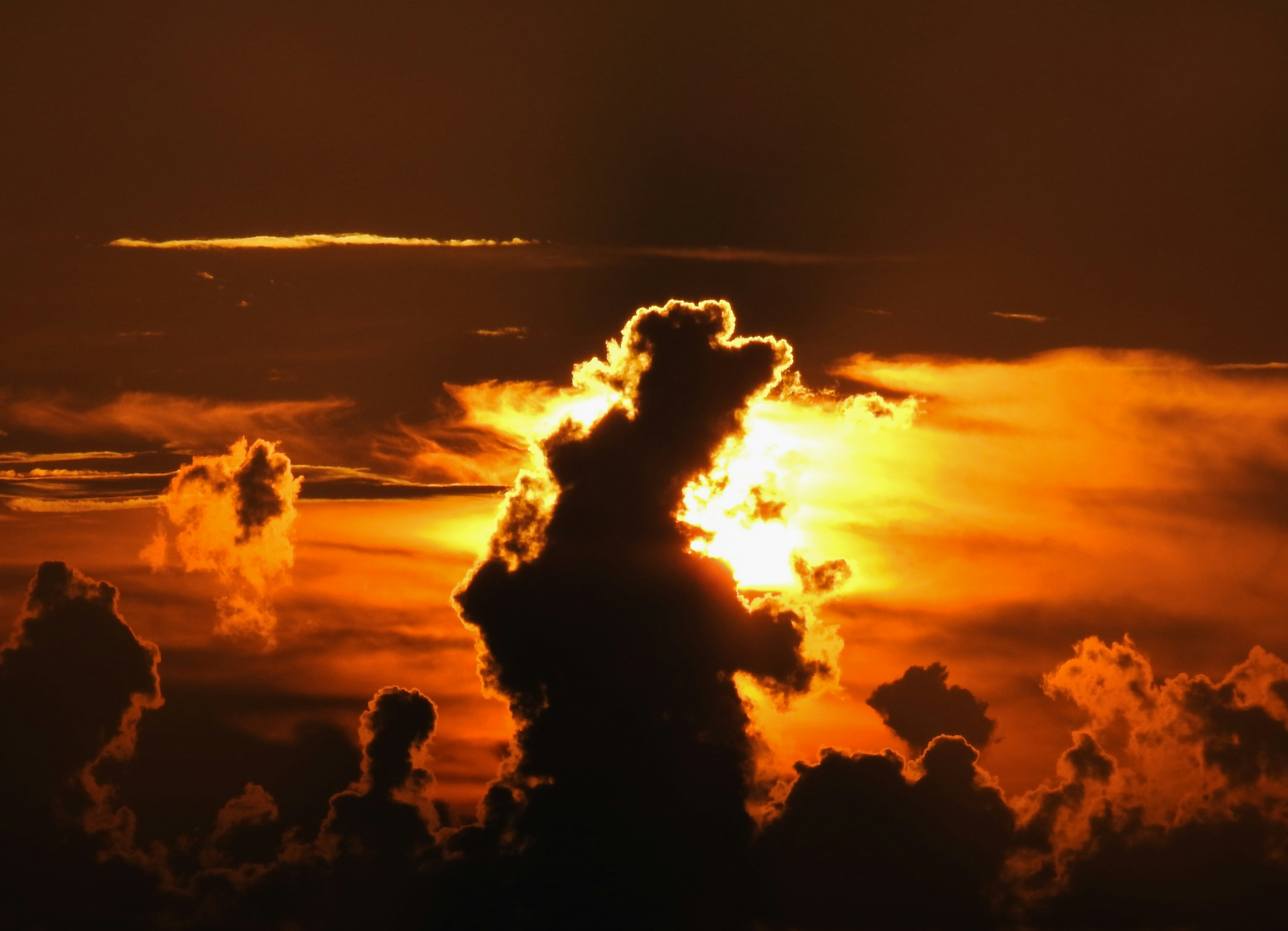 Dramatic clouds silhouetted against a vibrant sunset, creating a striking contrast of colors and shapes.
