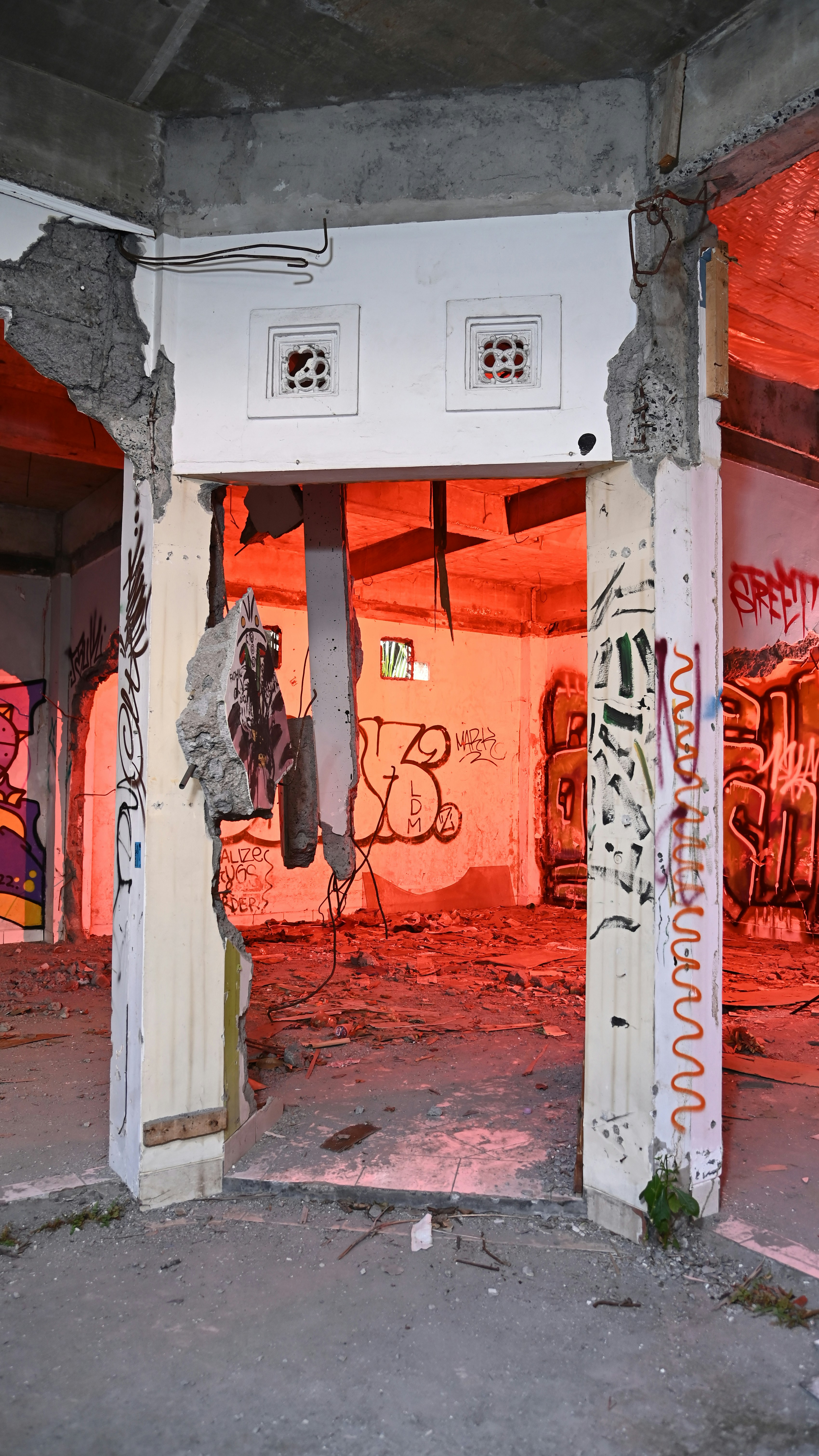 Crimson Threshold: Graffiti-Riddled Archway in a Derelict Shelter