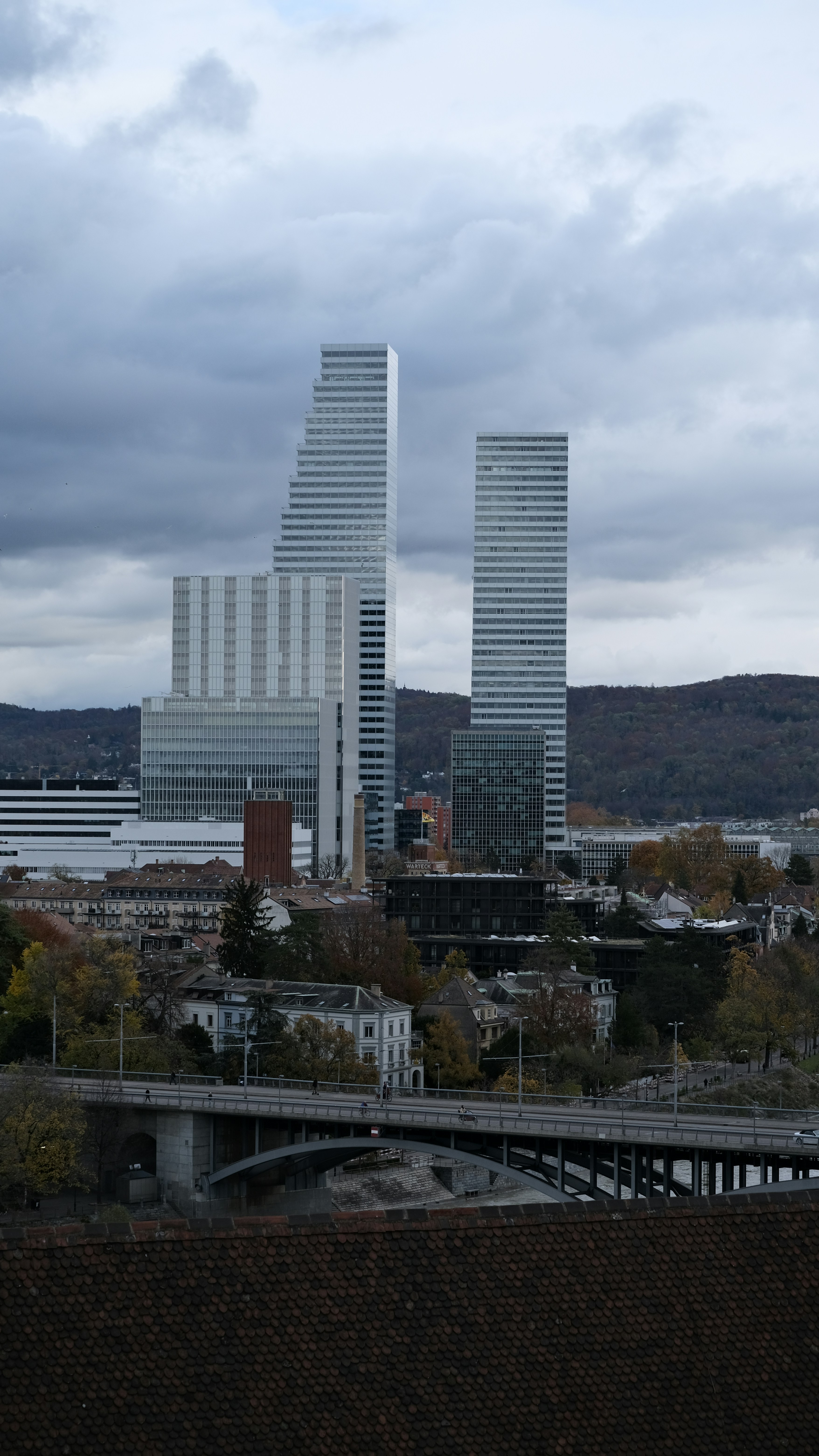 Twin Glass Giants Framing a Clouded Riverside Skyline