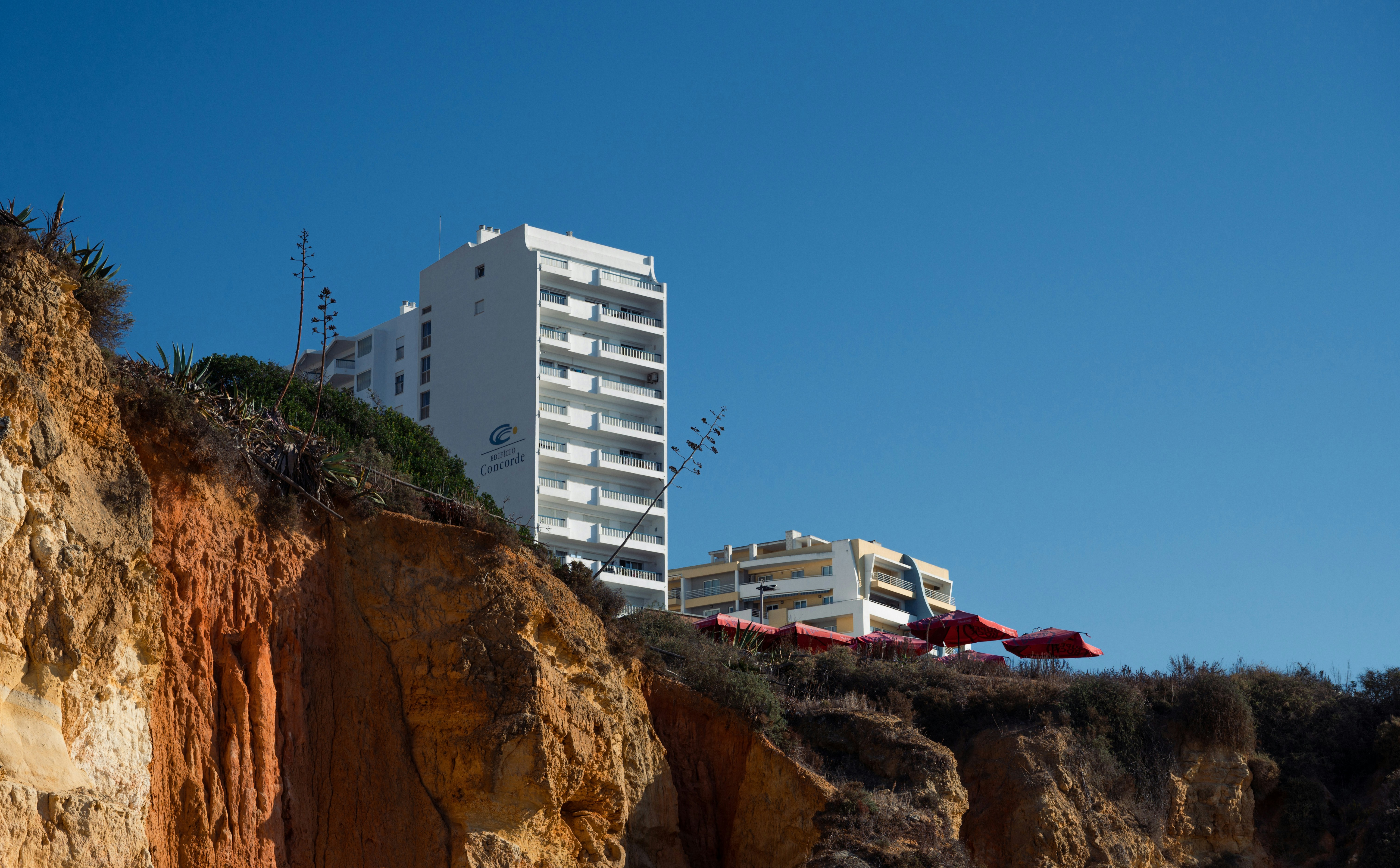Cliffside White Tower Against a Crisp Coastal Blue