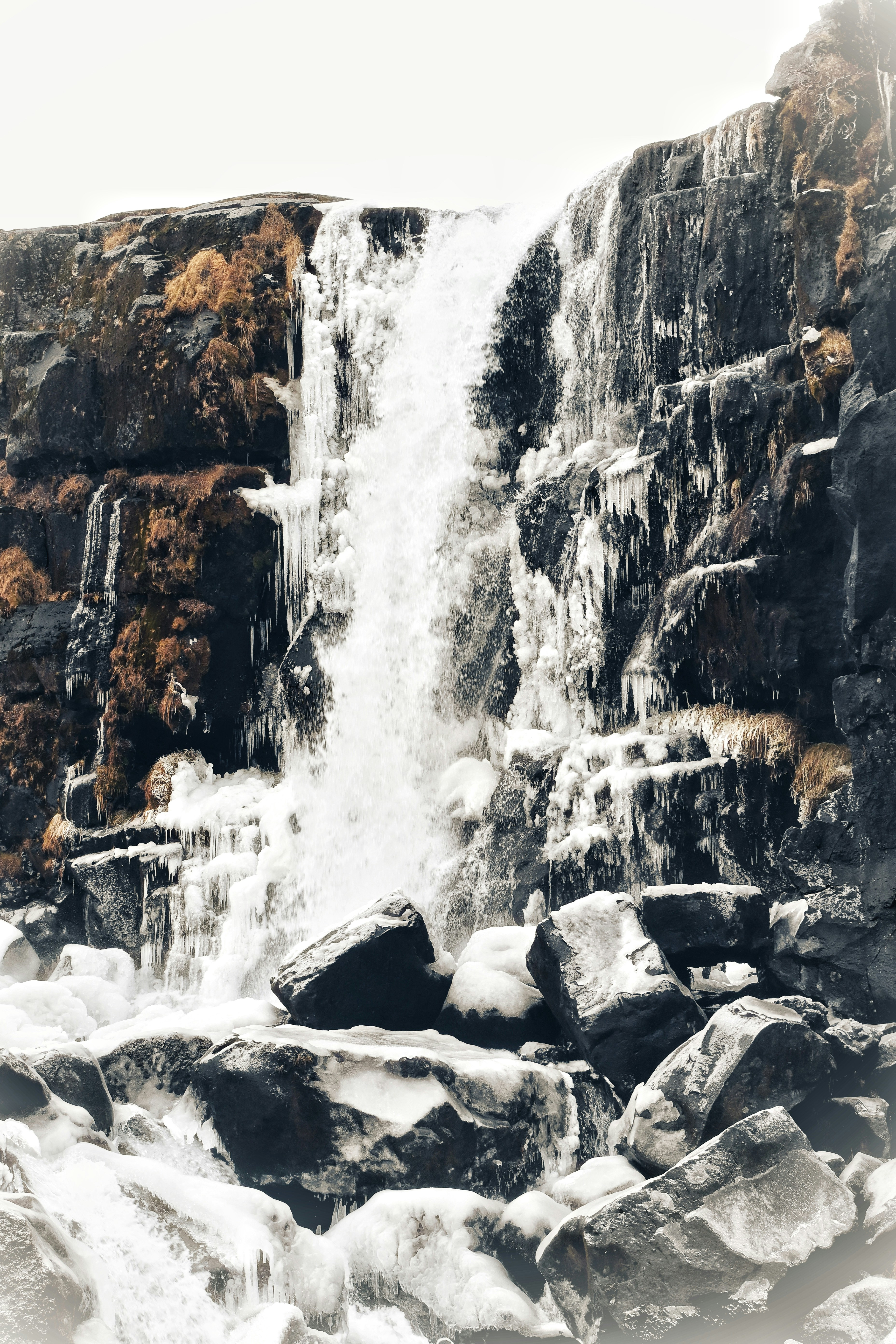 A waterfall with snow on the rocks and ice on the ground photo – Free ...