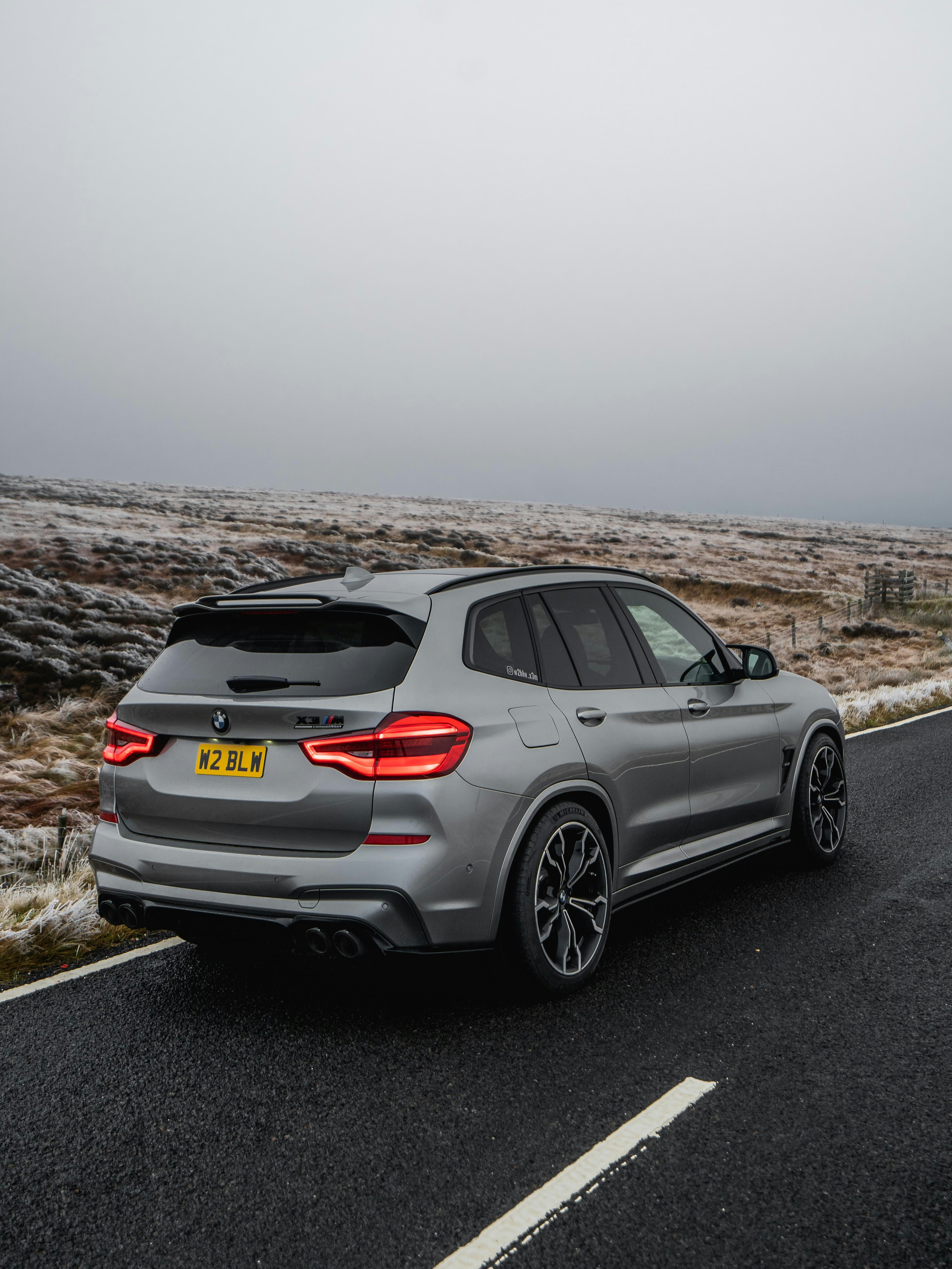 A silver bmw suv driving down a road photo – Free Bmw x3m× msport× cars ...