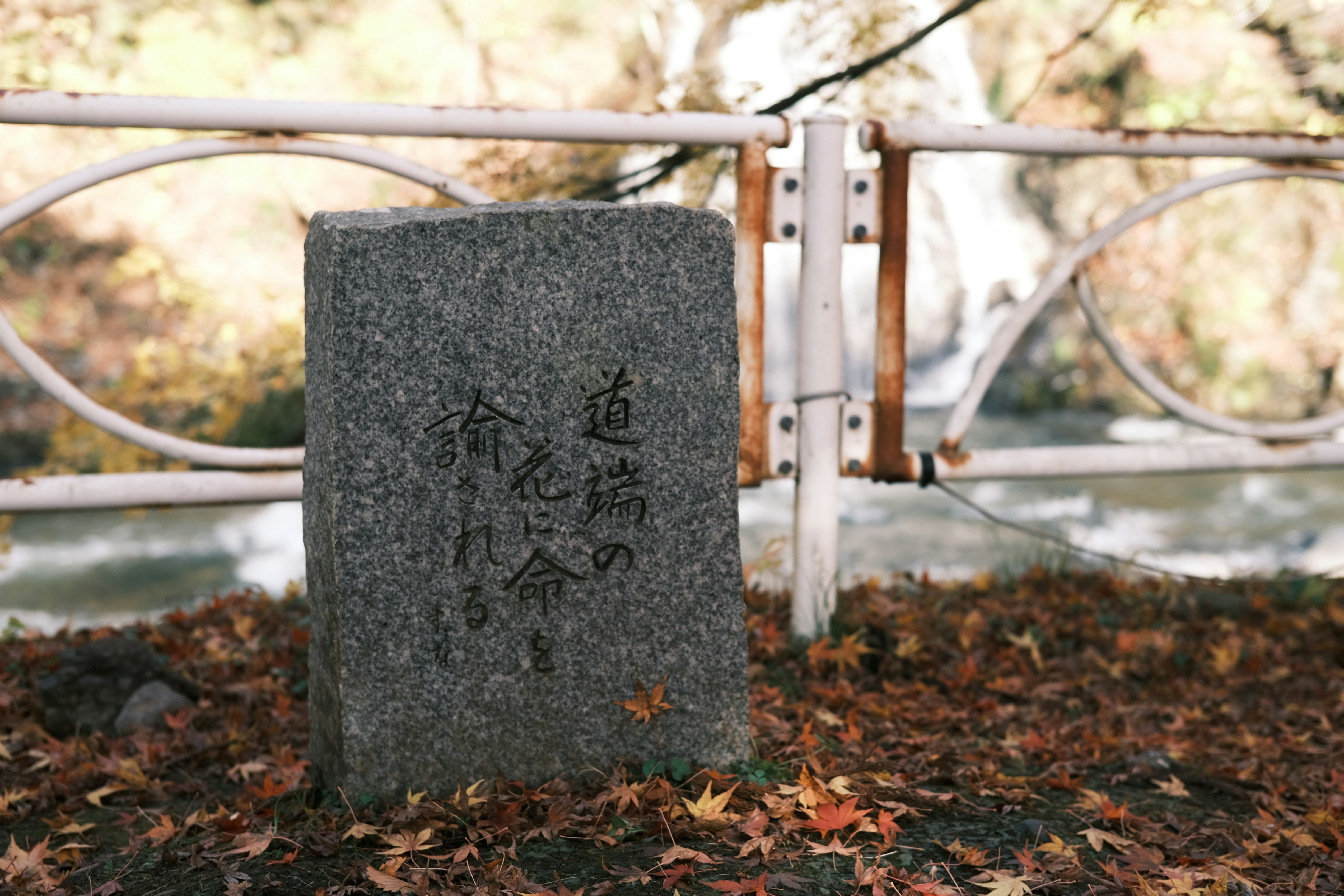 A stone with writing on it in front of a fence photo – Free Kuroishi ...