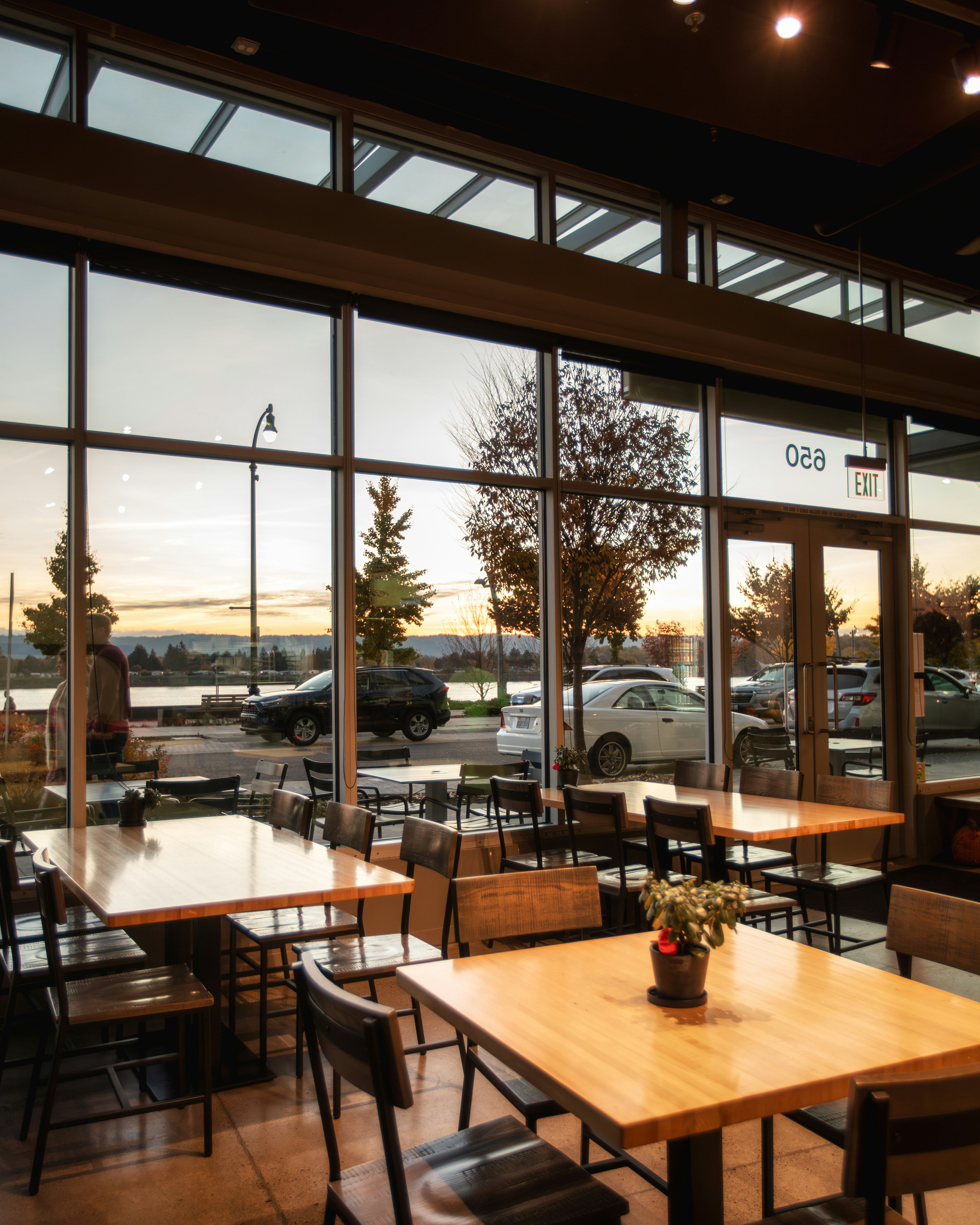 A restaurant with large windows and wooden tables photo – Free Ruse ...