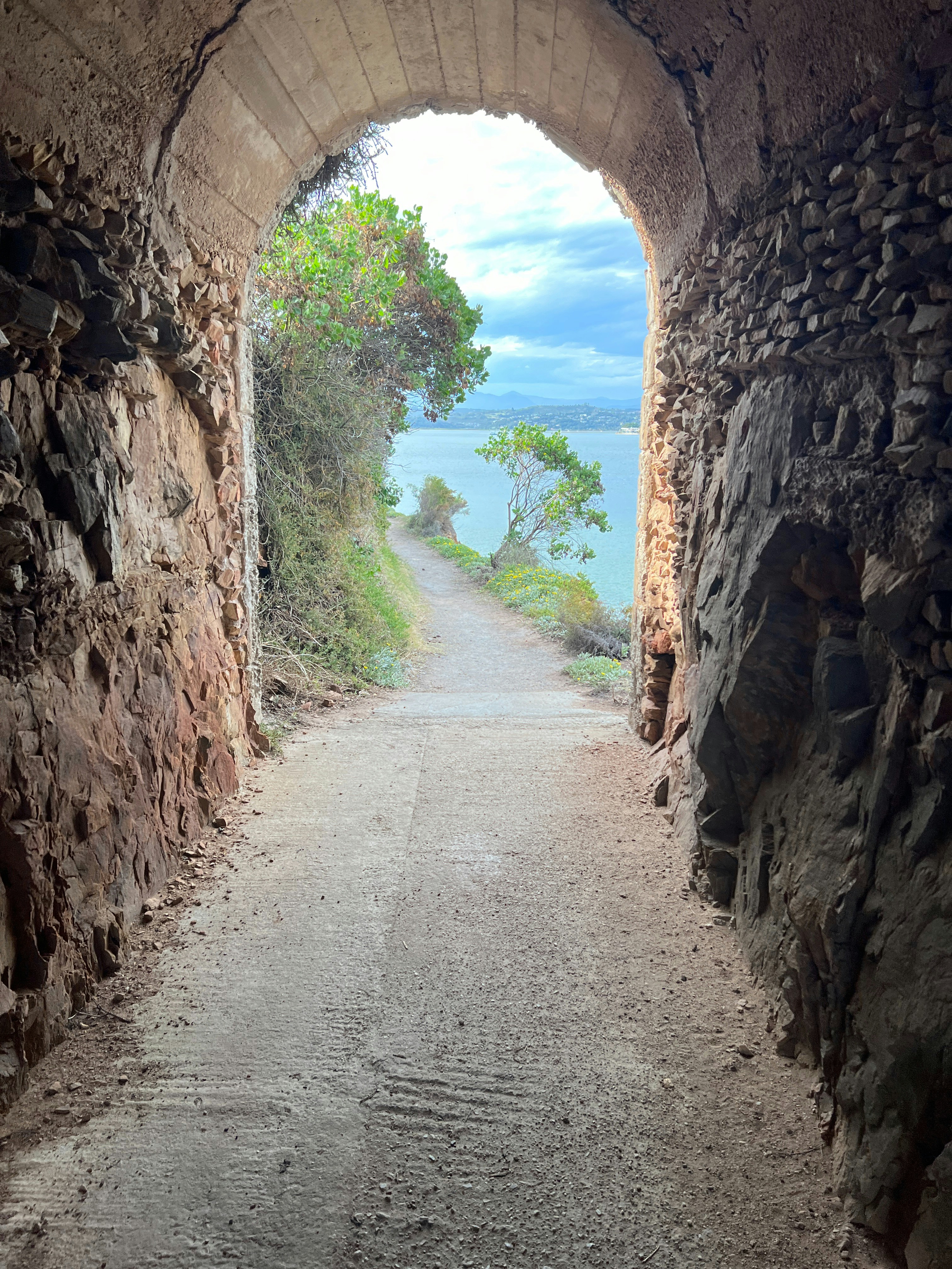 Threshold to the Lake: A Stone Arch Framing a Sunlit Path