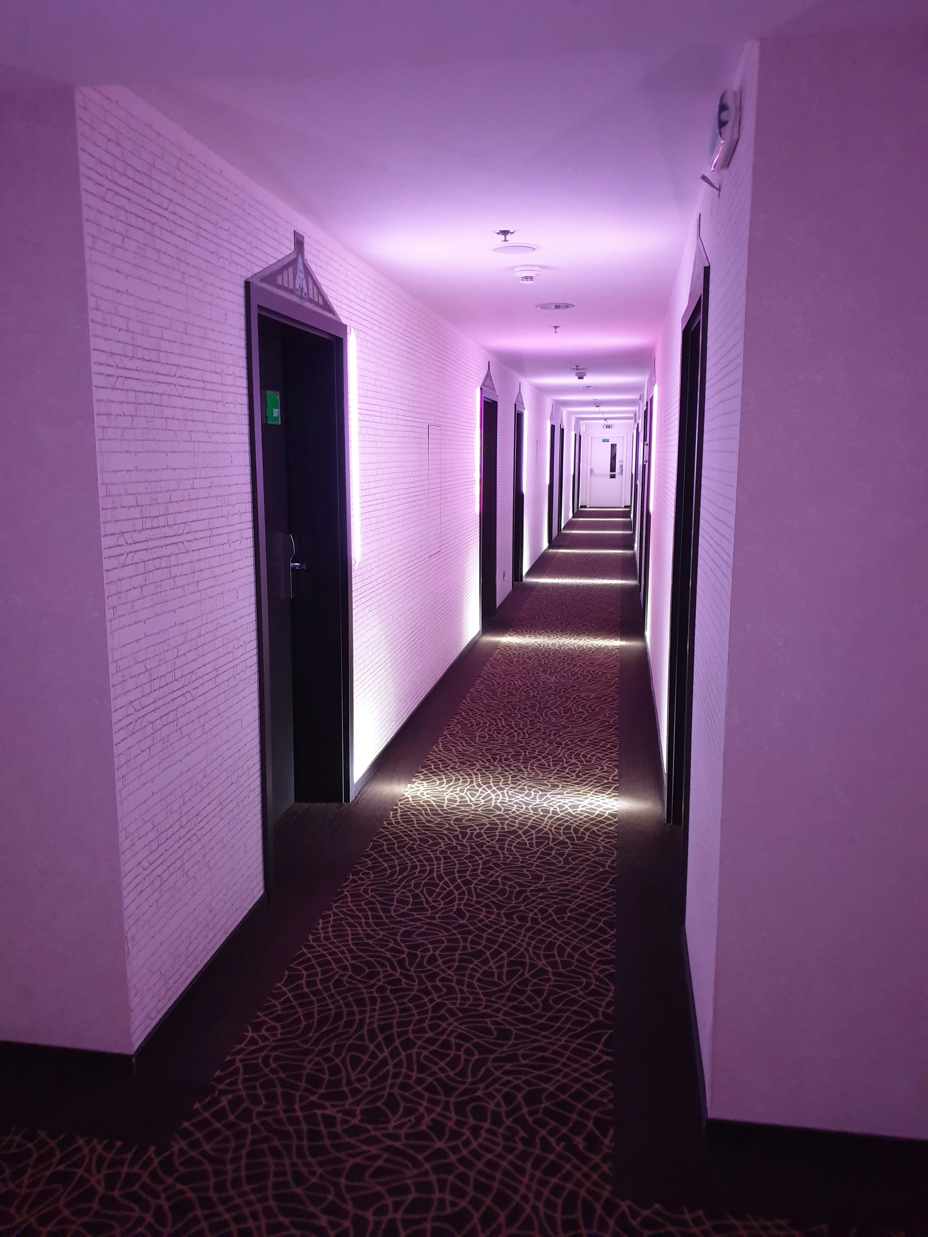Neon Convergence: A Violet-Hued Hotel Corridor