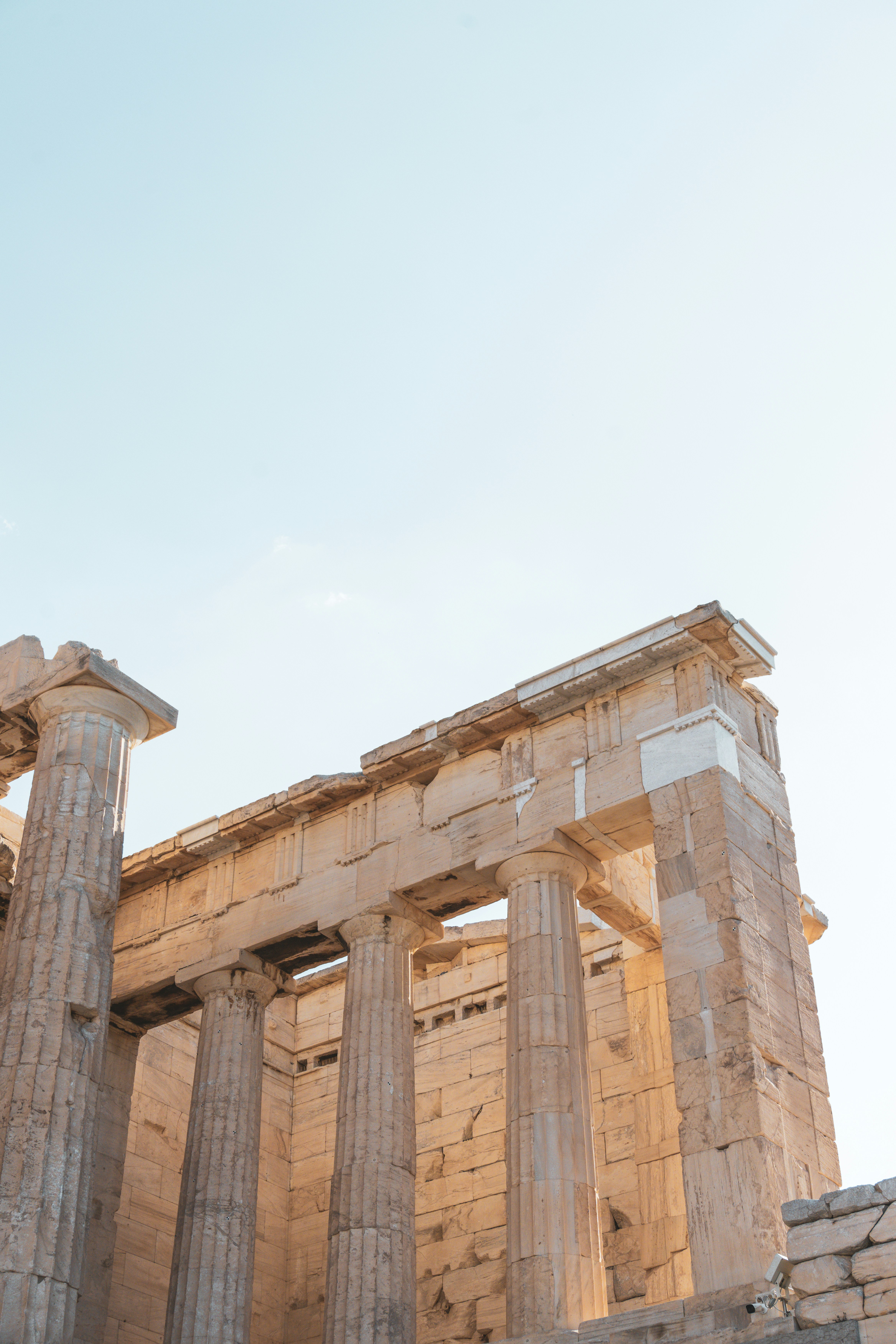 A tall stone building with two large pillars photo – Free Brown Image ...
