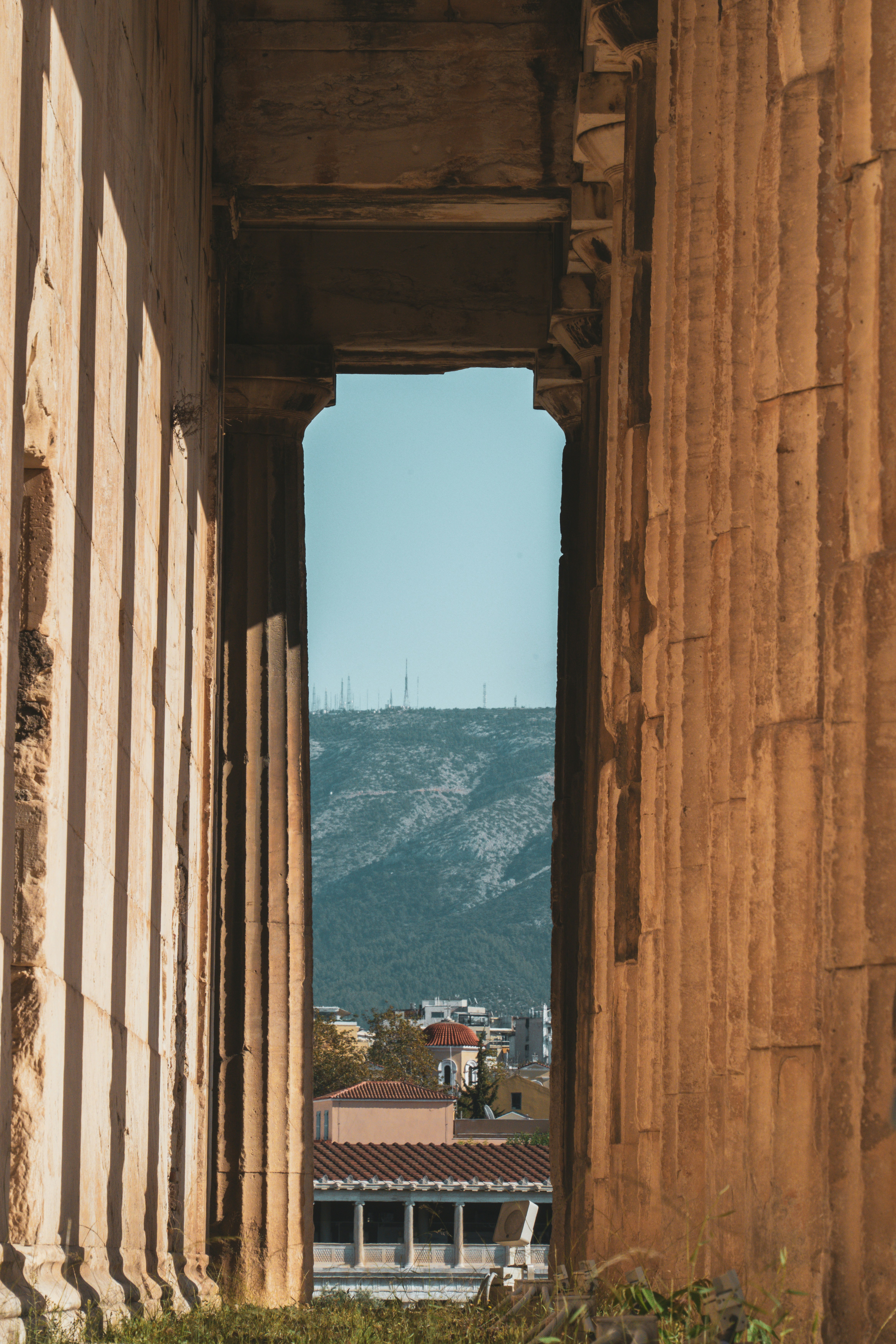 A building with columns and a clock tower in the distance photo – Free ...