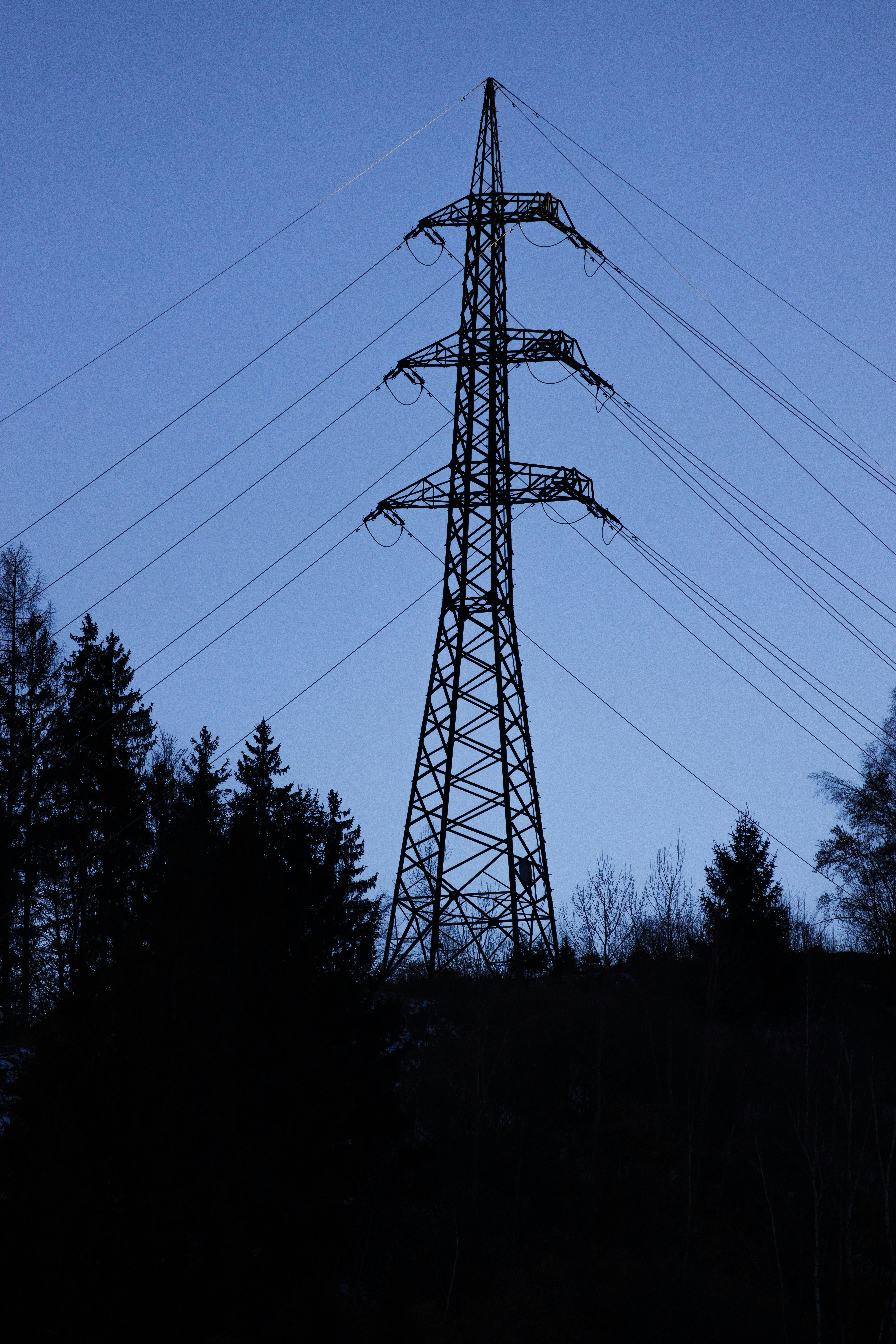 A high voltage power line with trees in the background photo – Free ...