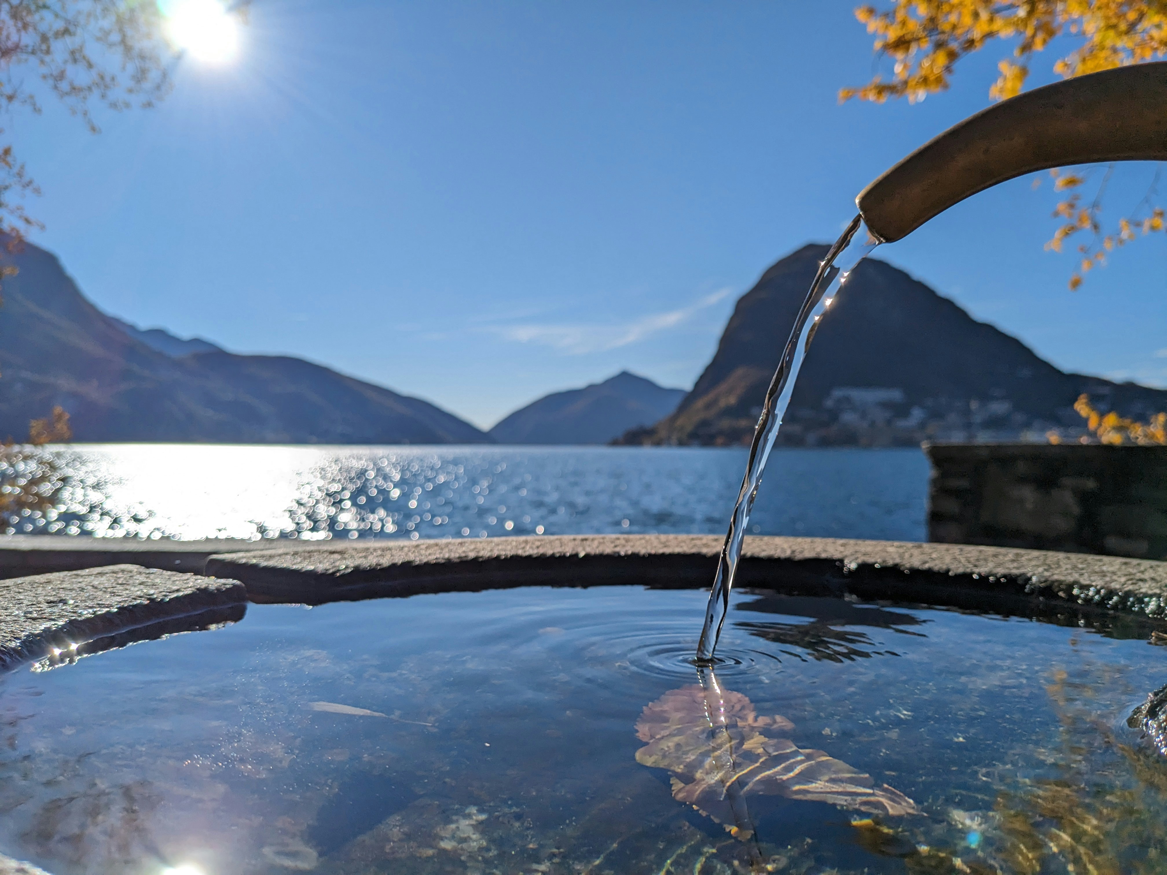 Sunlit Cascade into an Alpine Pool Over a Mountain Lake