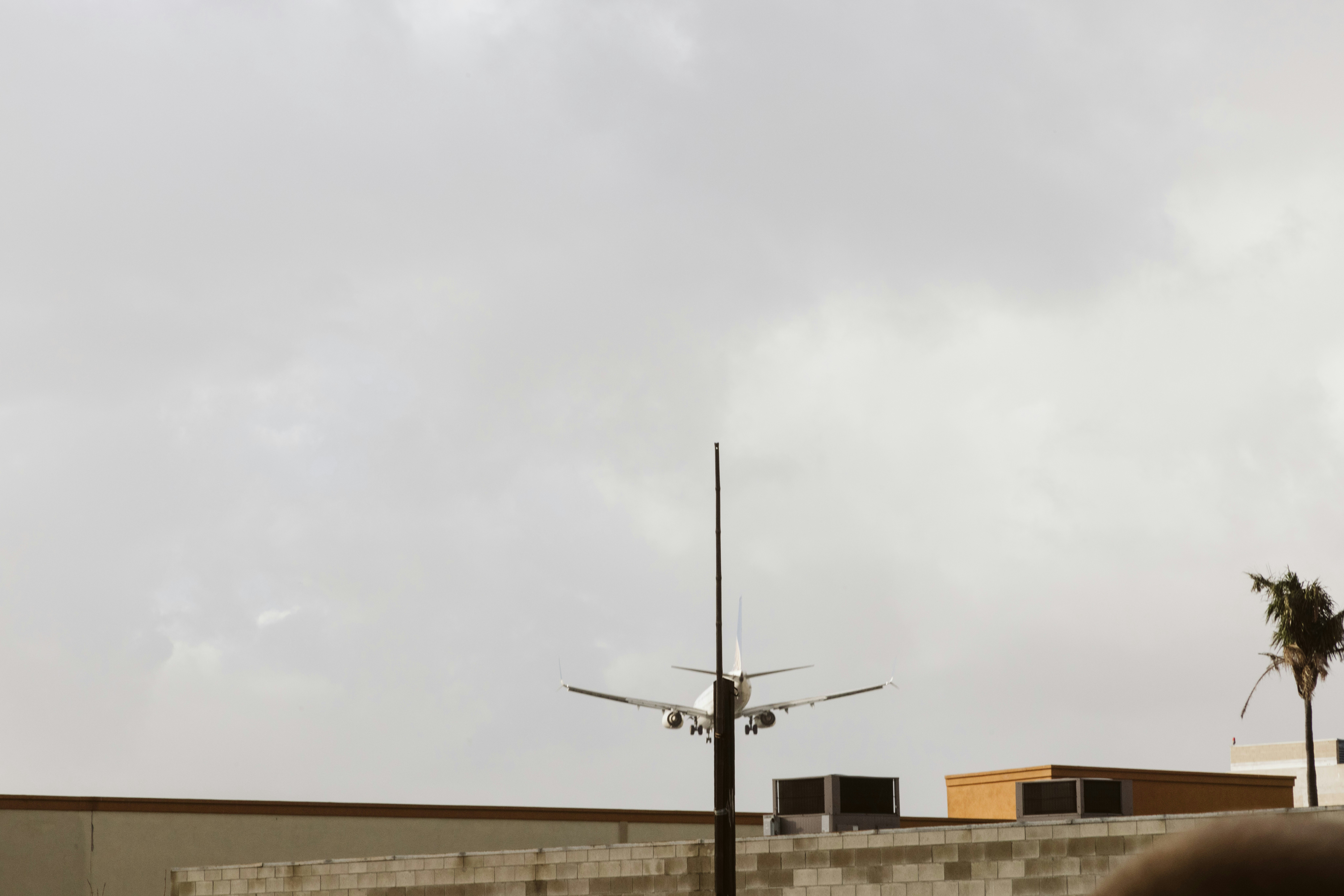 An airplane is flying over a concrete wall photo – Free Grey Image on ...