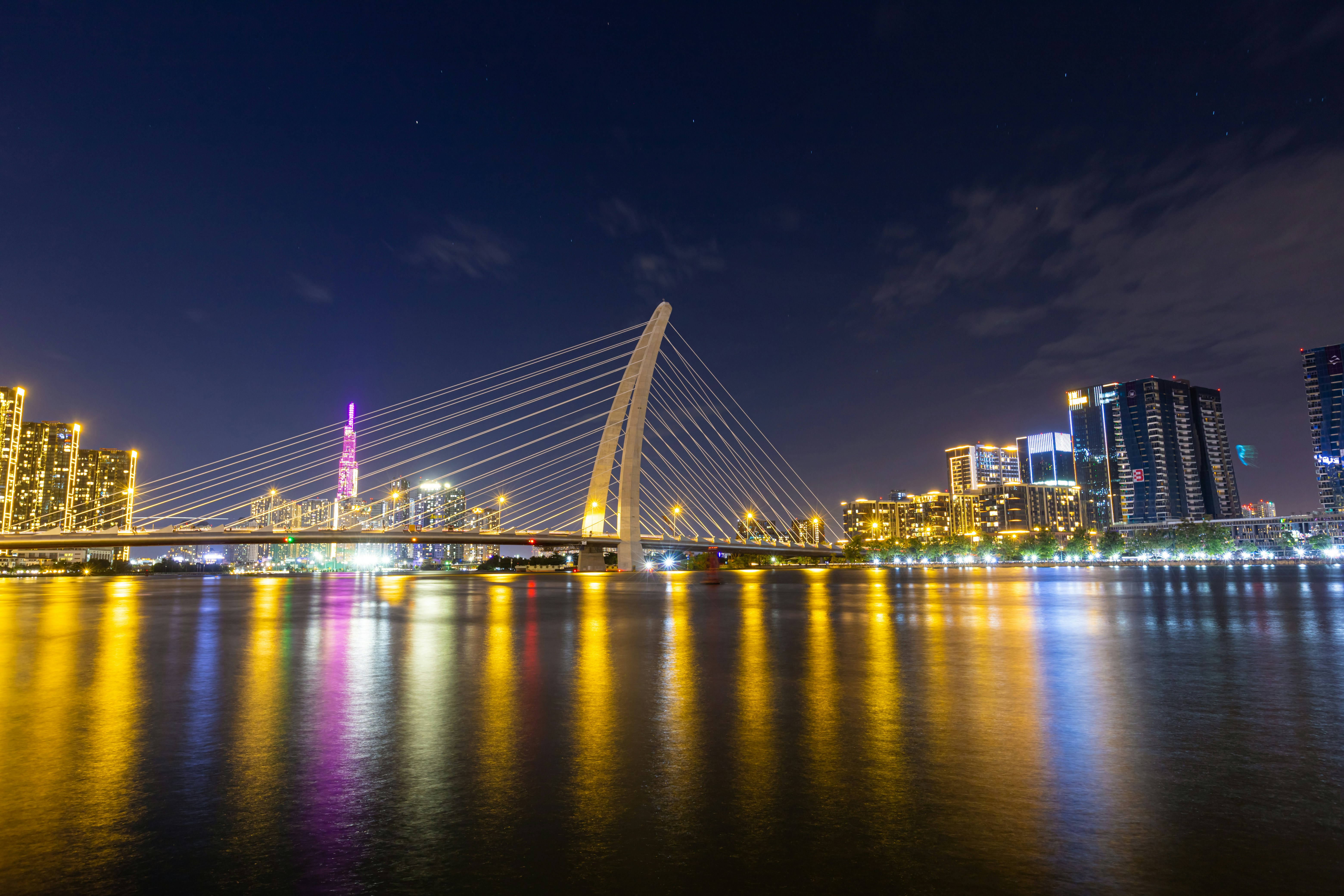 A bridge over a river with a city in the background photo – Free ...