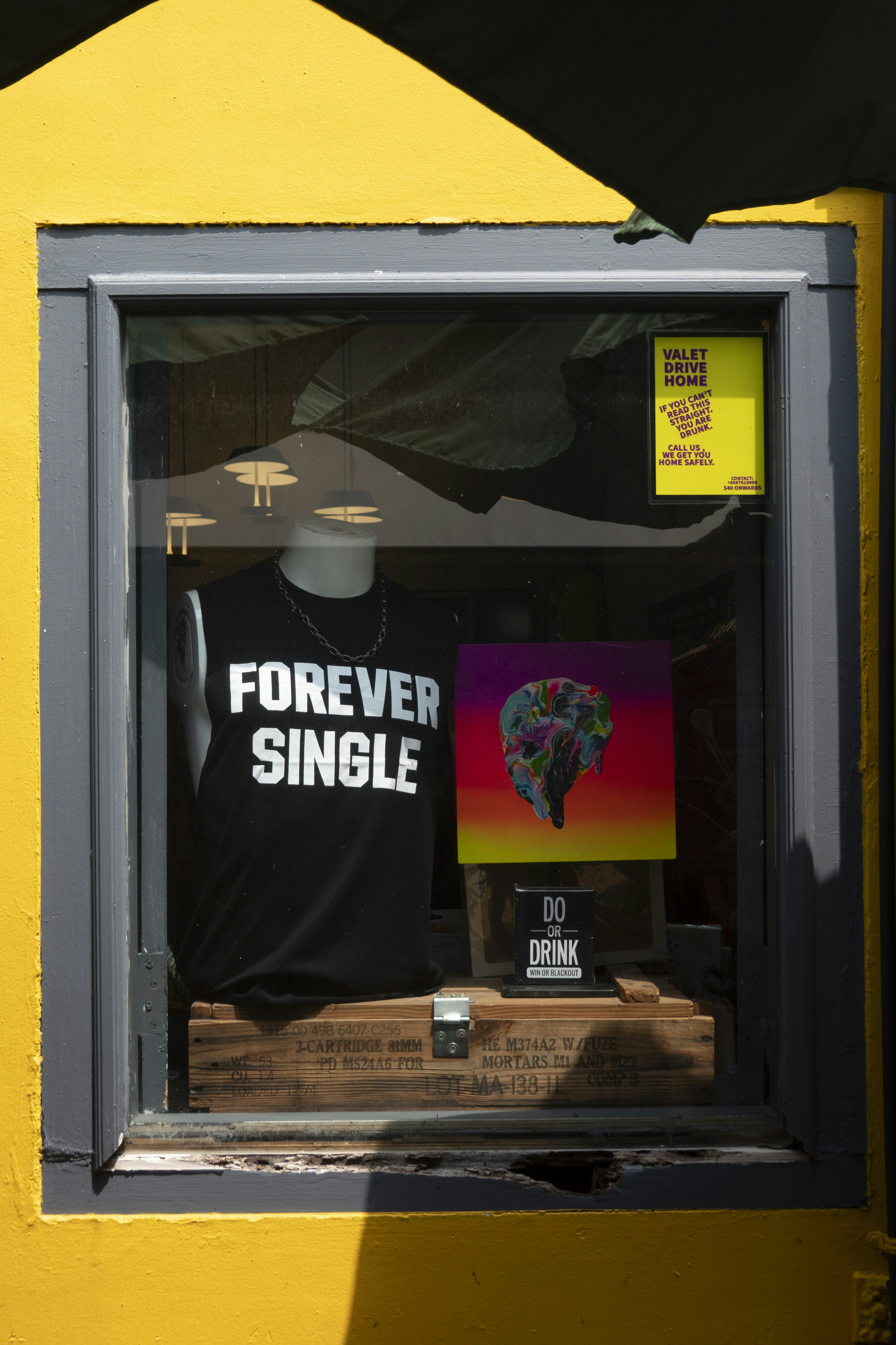 Forever Single Tee Framed by a Colorful Poster in a Yellow Shop Window