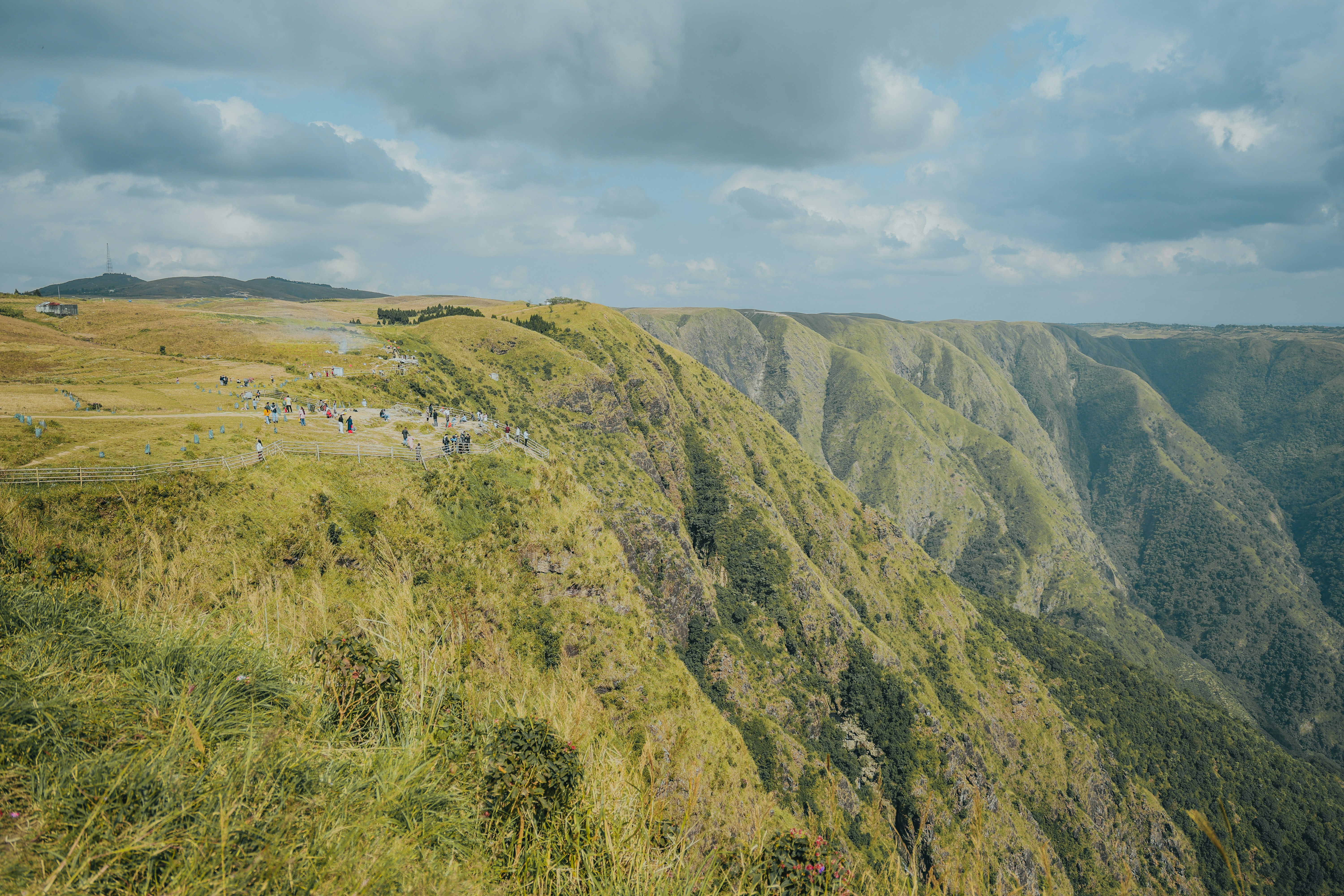 Edge of the Emerald Ridge: Hikers at a Grass-Lined Cliff Overlook