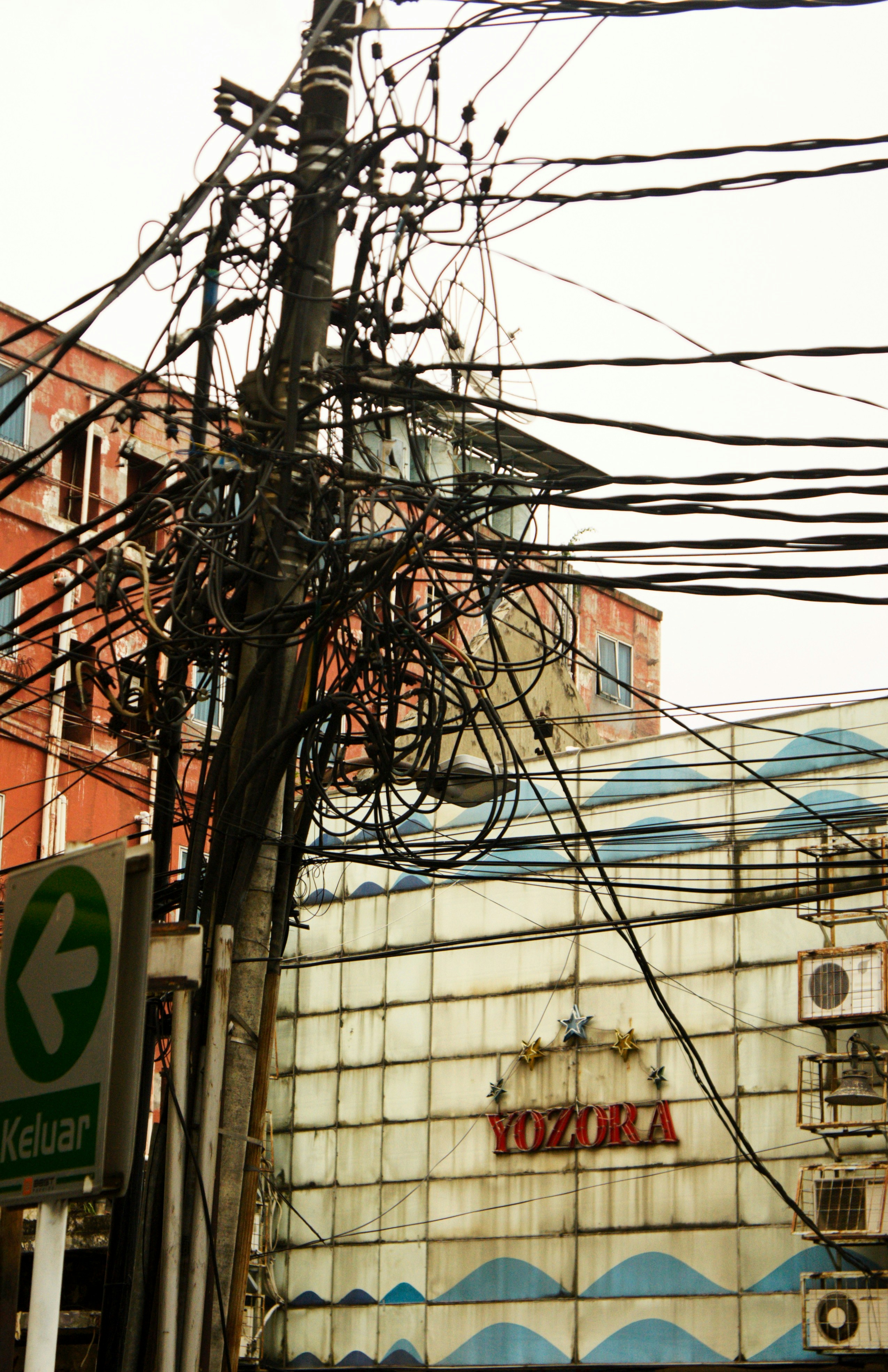 Un montón de cables colgando de un poste al lado de un edificio foto ...