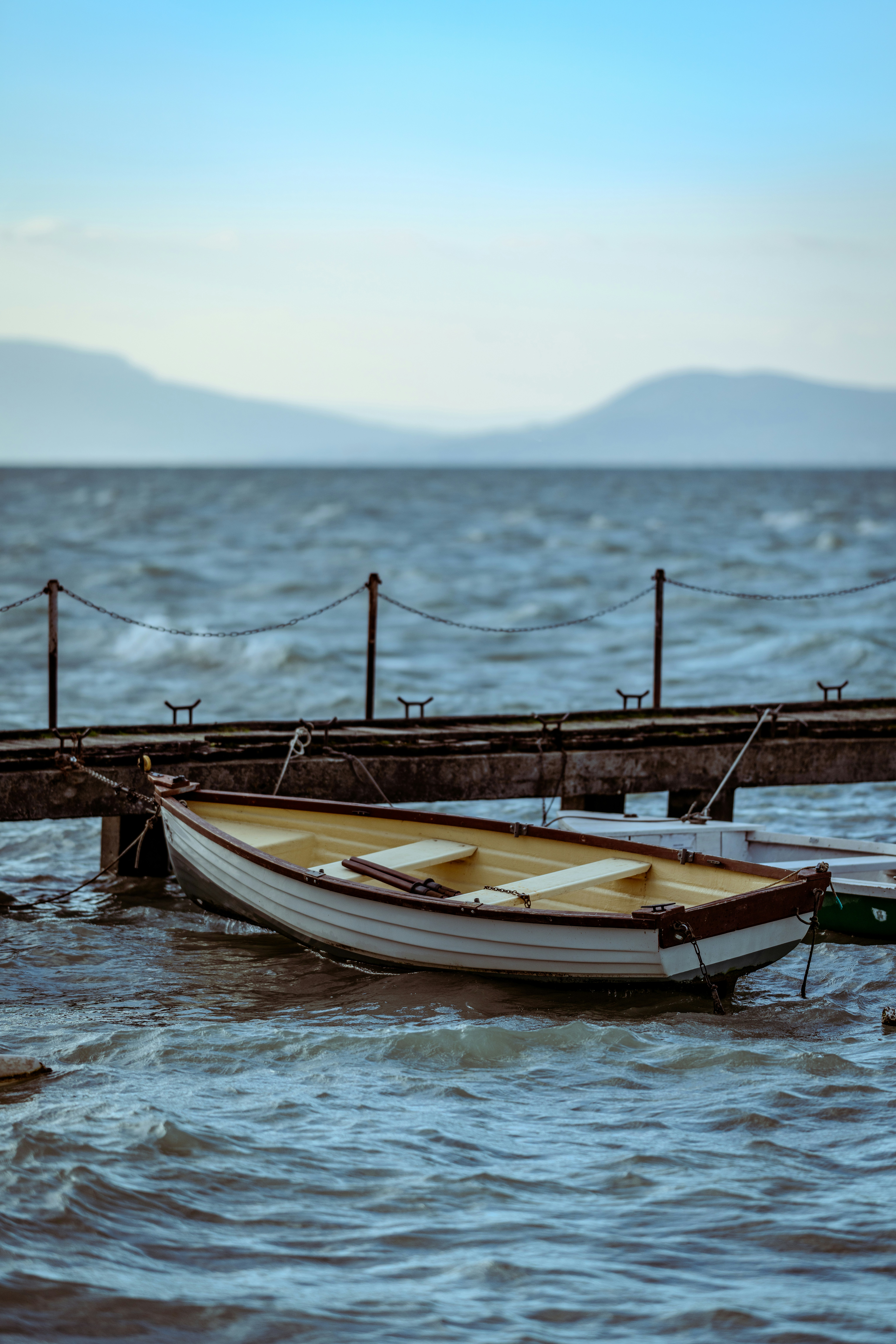 Foto zum Thema Ein kleines Boot, das an einem Steg im Wasser ...