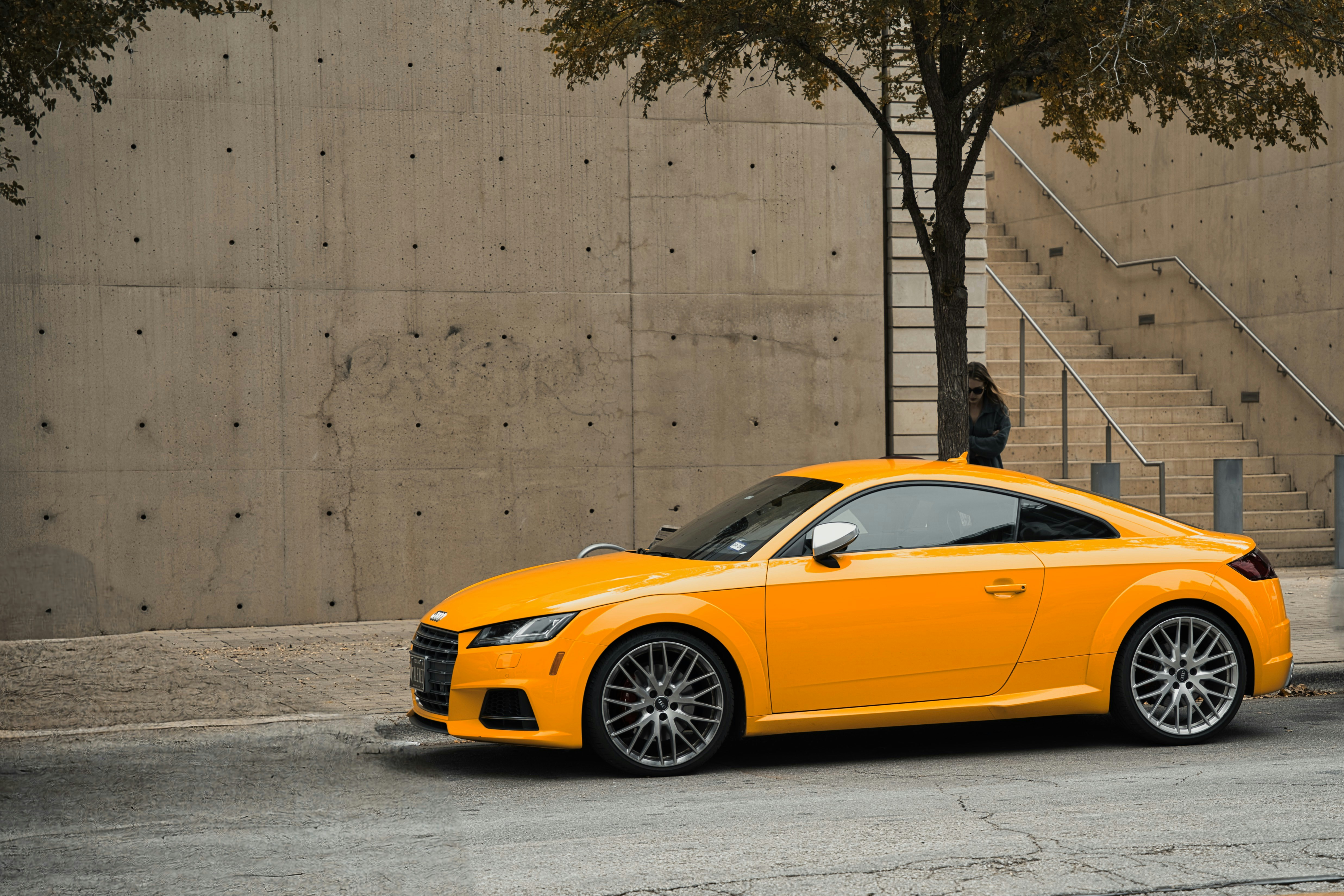 Urban Ember: A Bright Orange Coupe Anchored by Concrete Lines