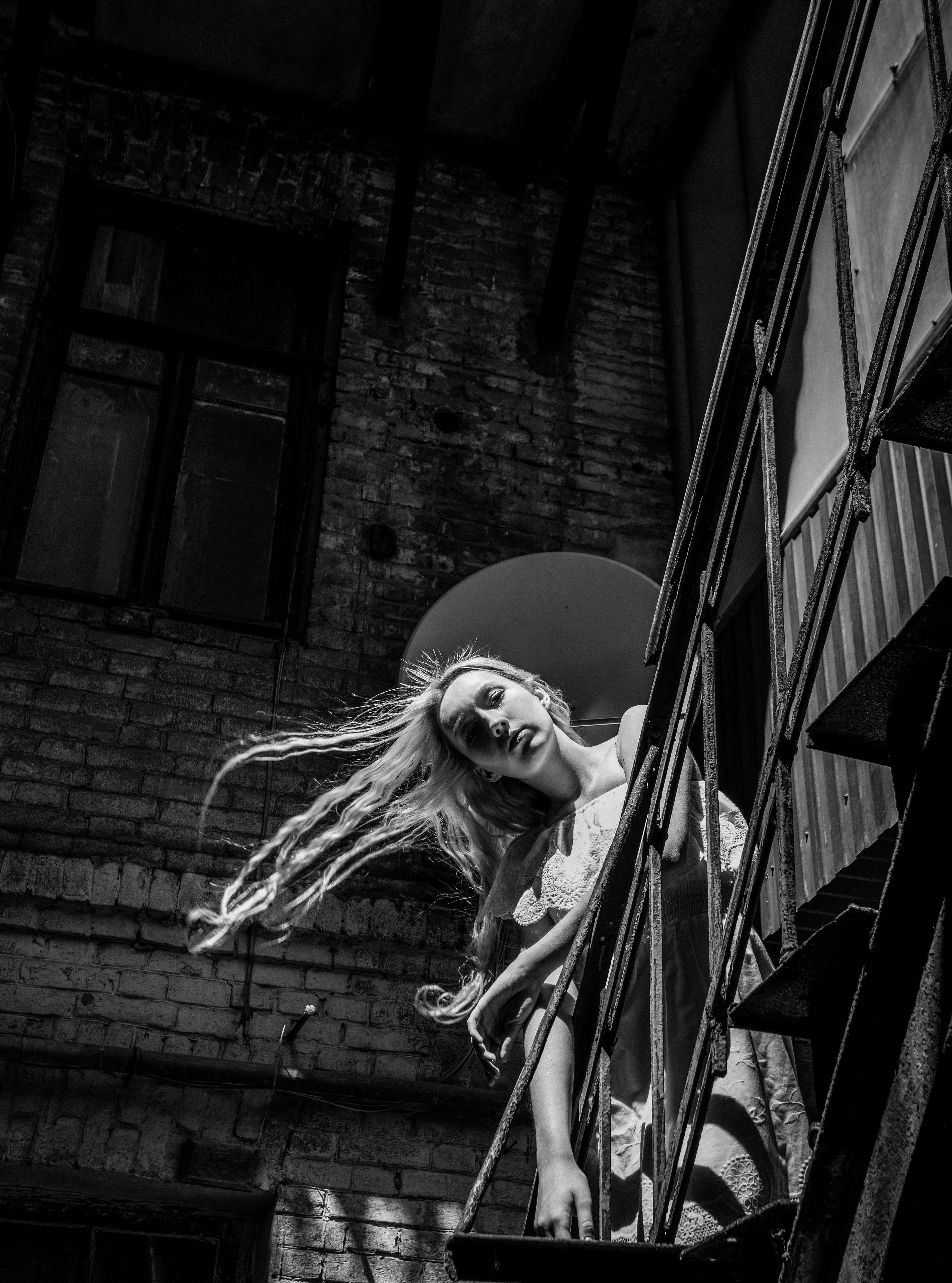 Hair in the Wind Over a Bricked Fire Escape