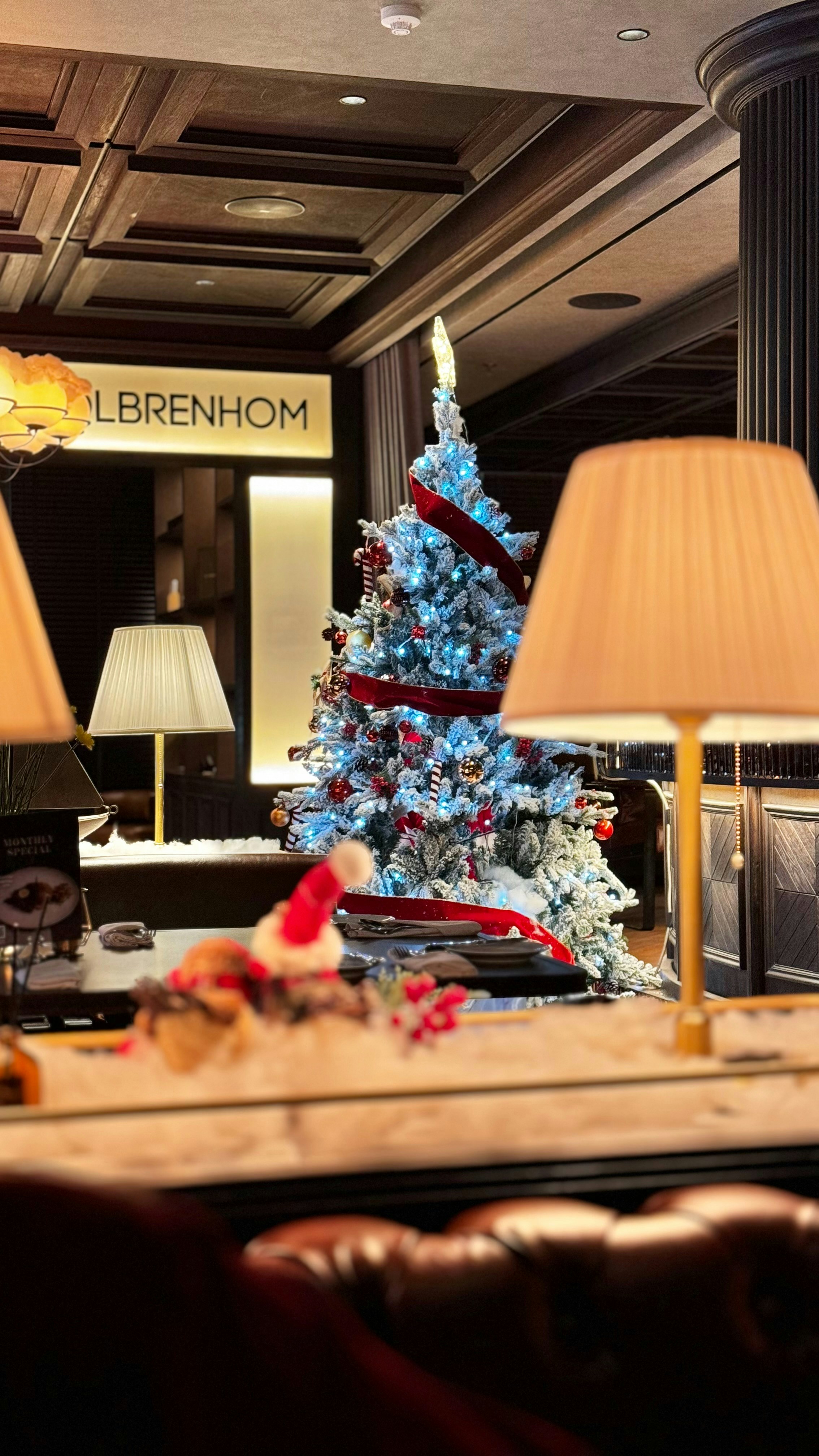 Snowy Christmas Tree in a Warm Restaurant Lounge