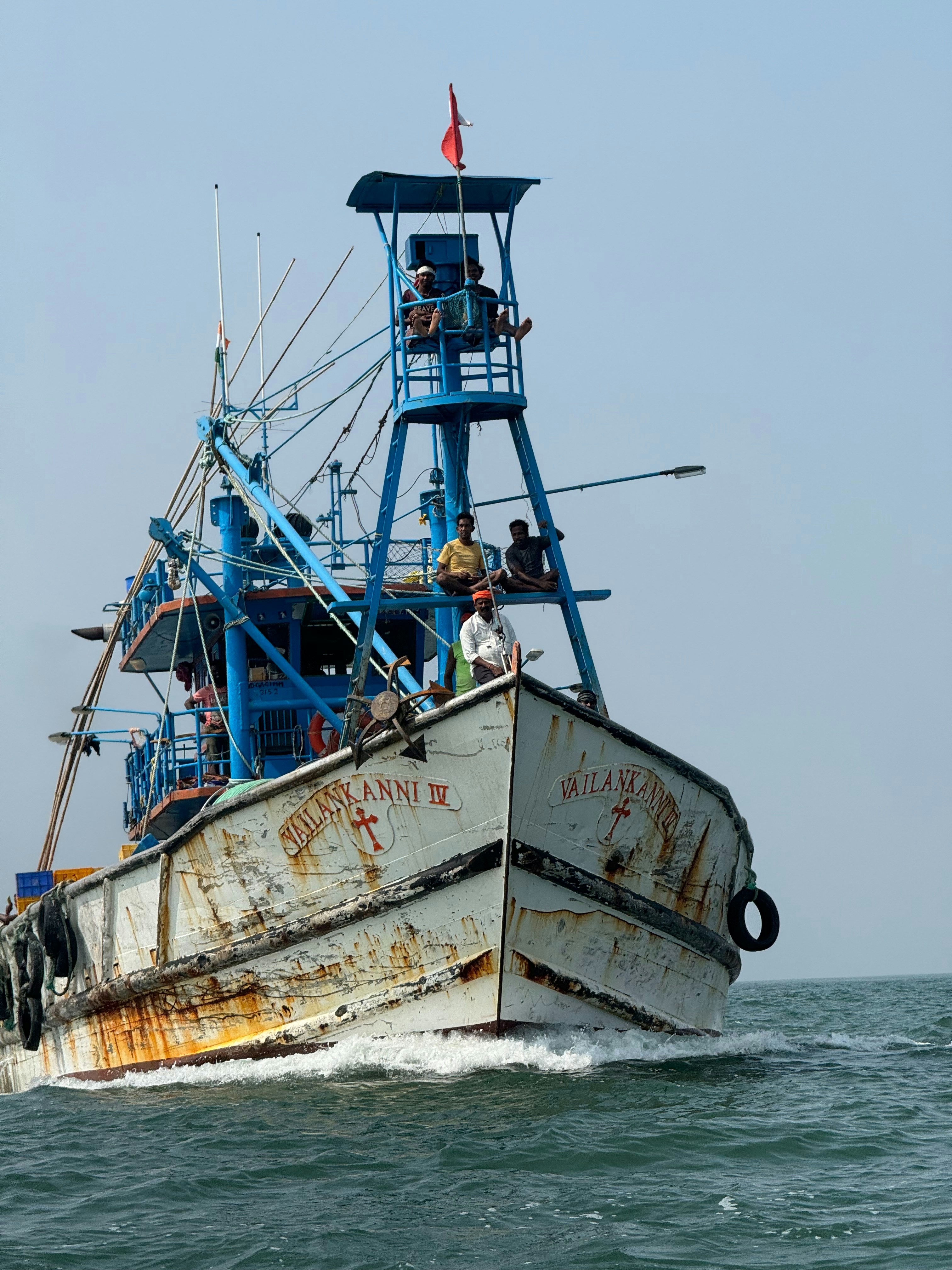 Blue-Decked Drift: A Weathered Fishing Vessel Slicing the Sea