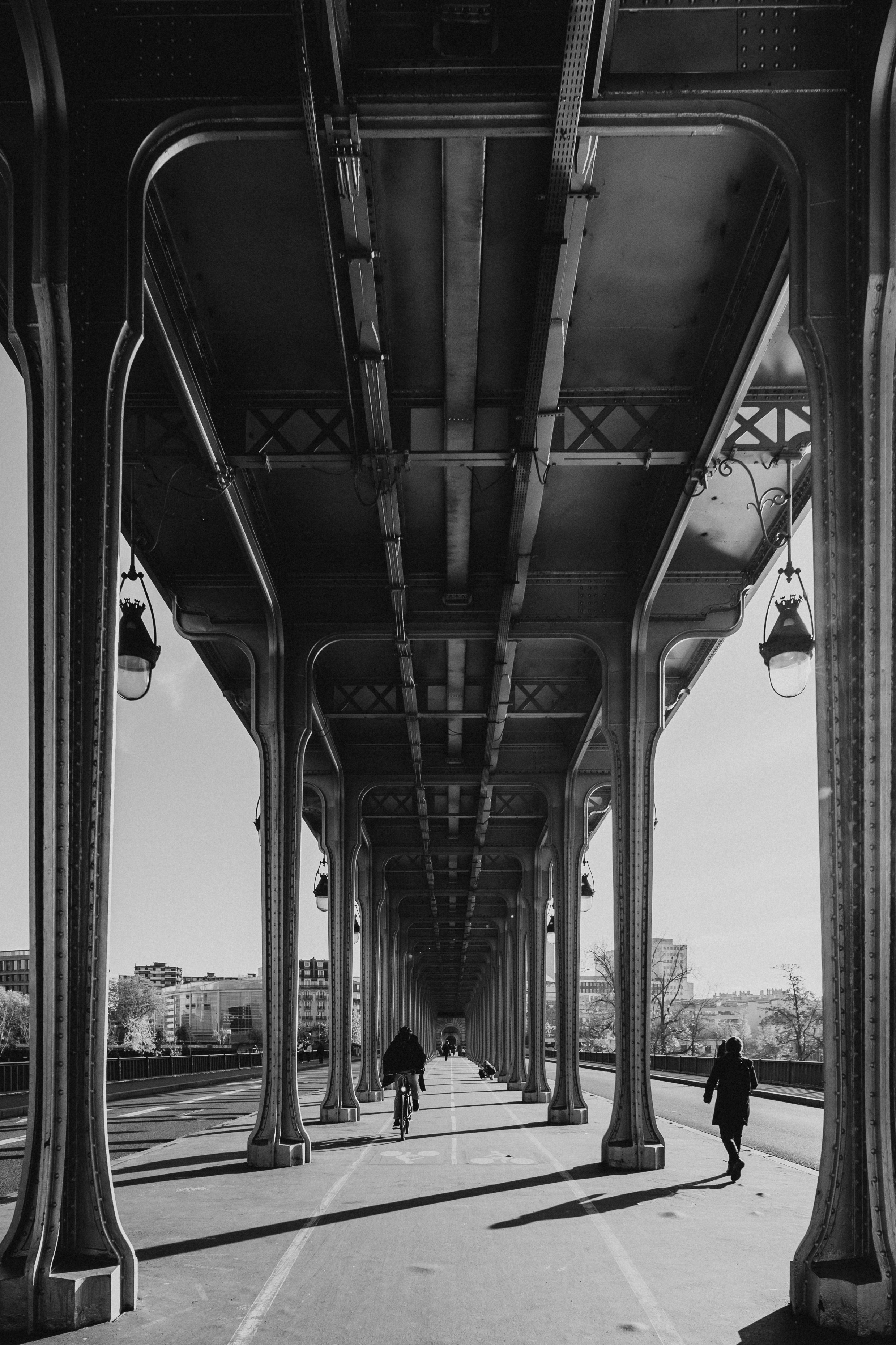 A black and white photo of people walking under a bridge photo – Free ...