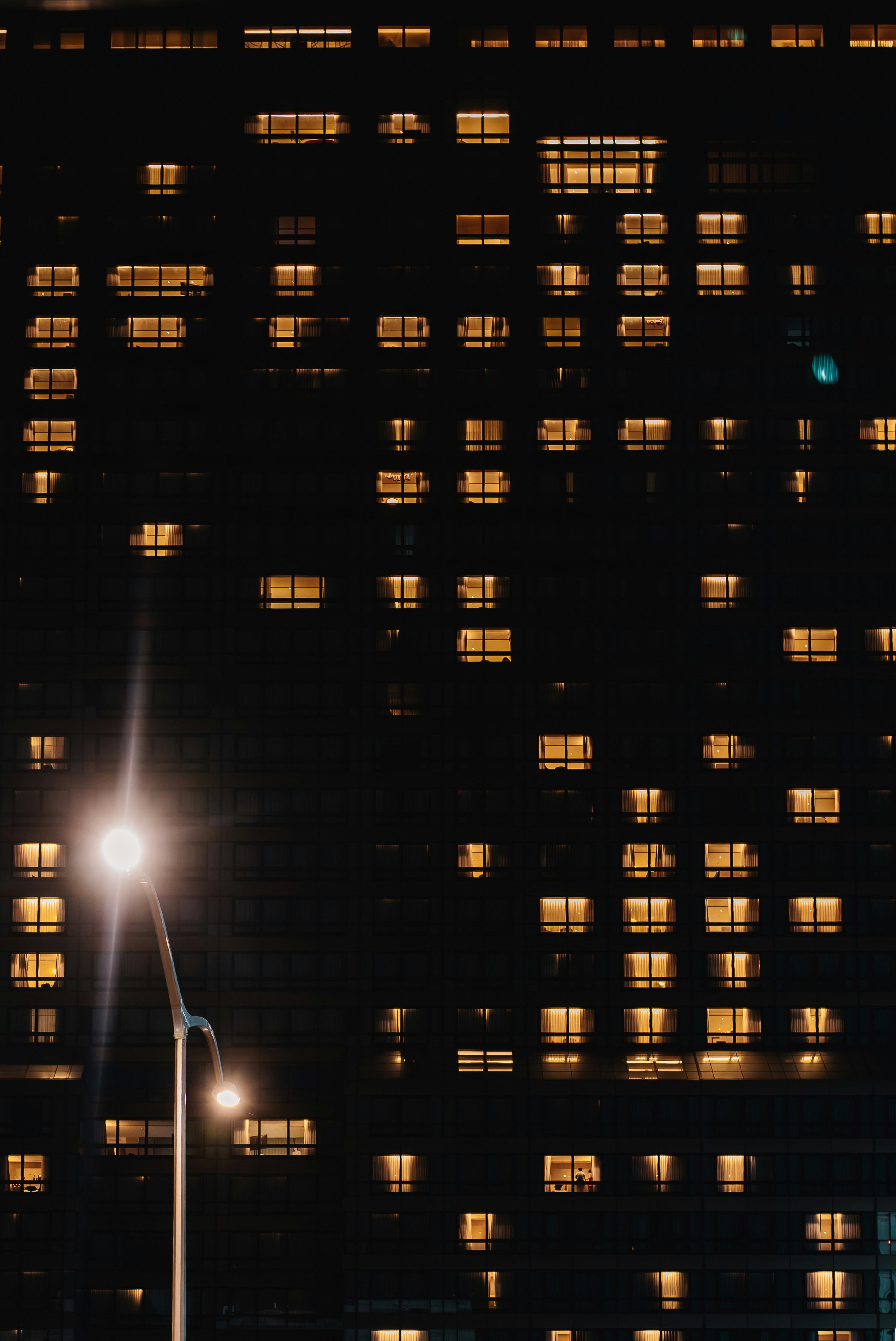 A building with many windows lit up at night photo – Free City Image on ...