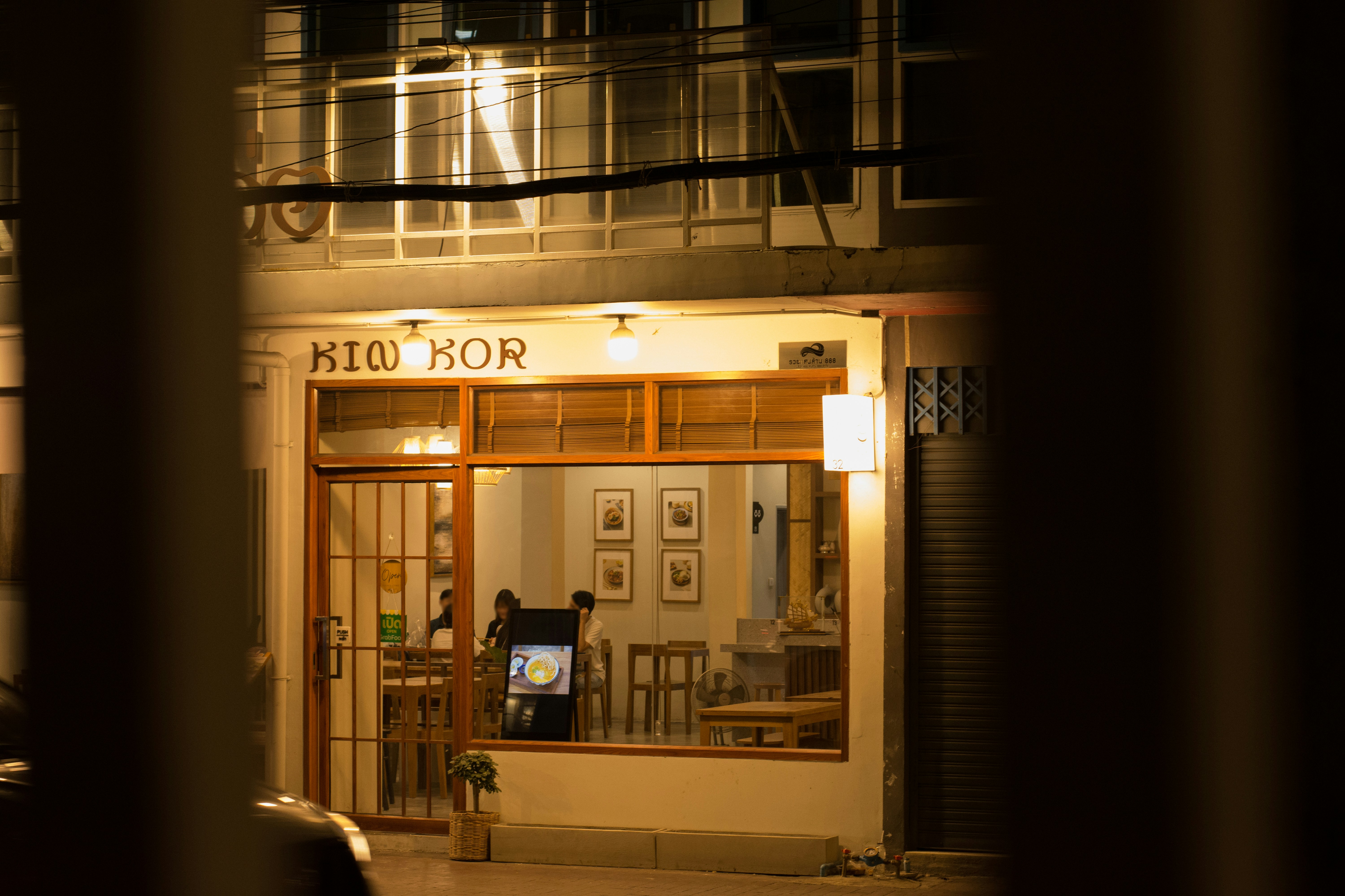 A store front at night with a lit up window photo – Free City Image on ...