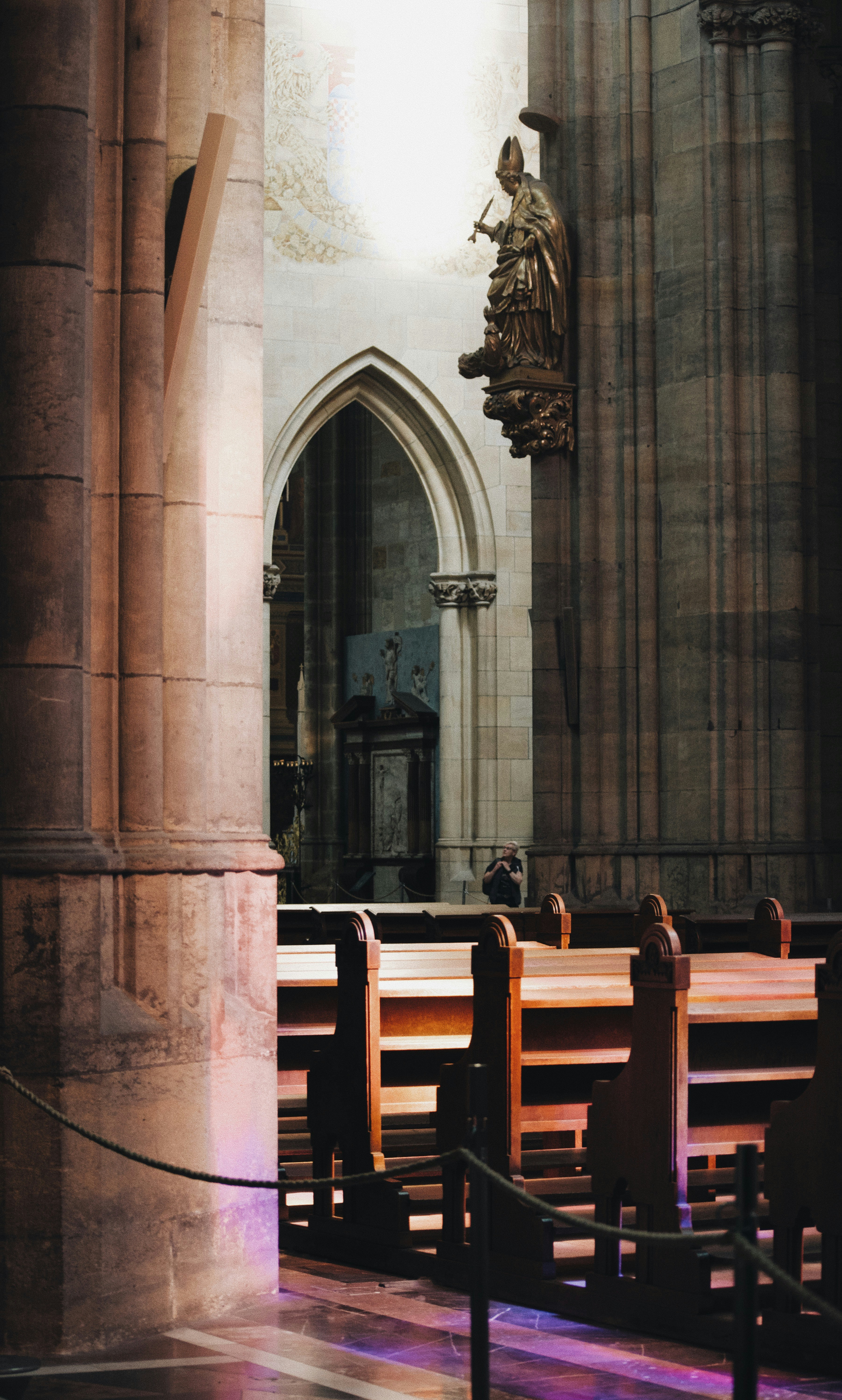 Saintly Sentinel in a Sunlit Gothic Nave