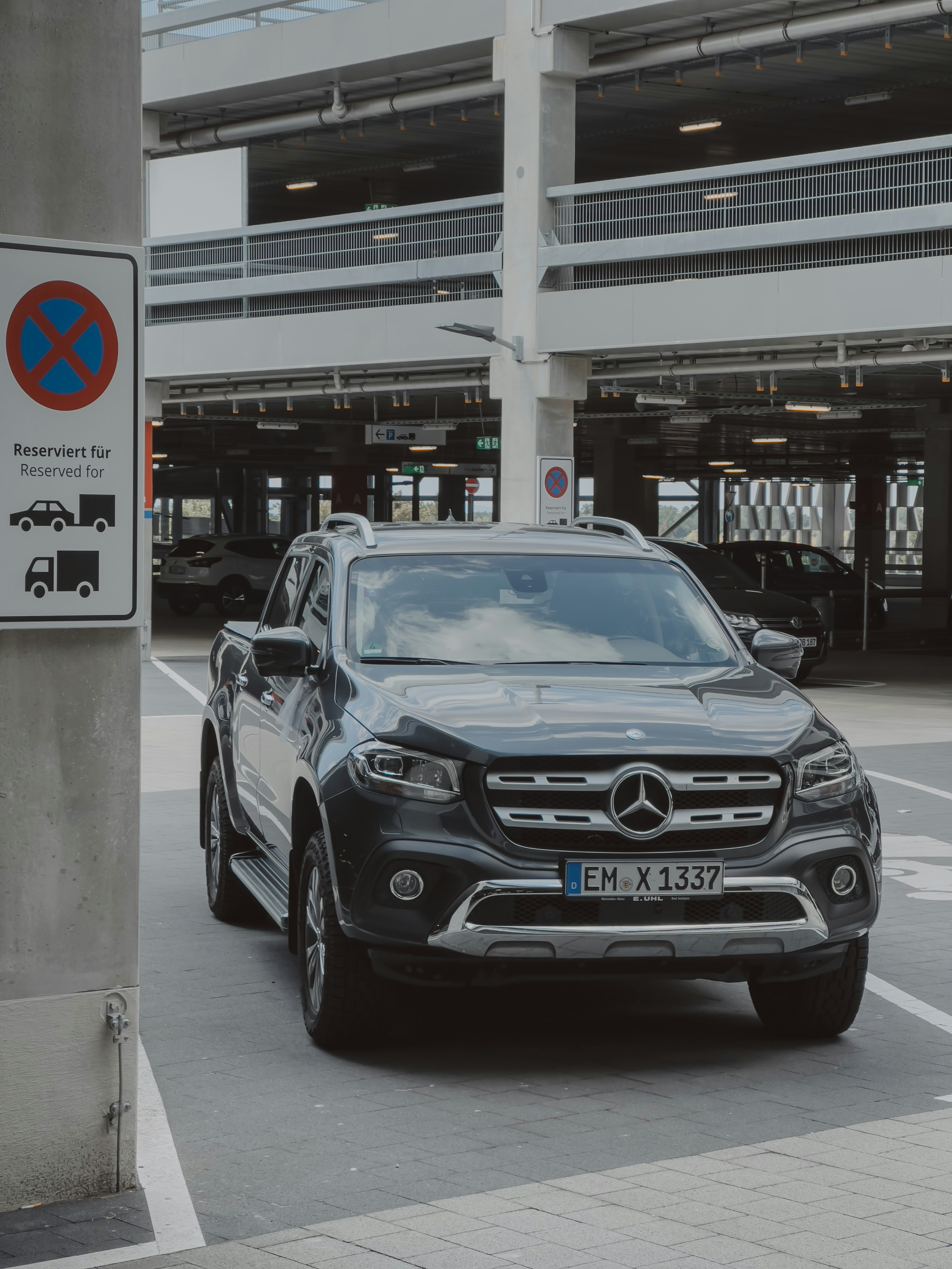 Chrome Grille in Concrete: Front View of a Mercedes-Benz SUV in a Multi-Level Parking Garage