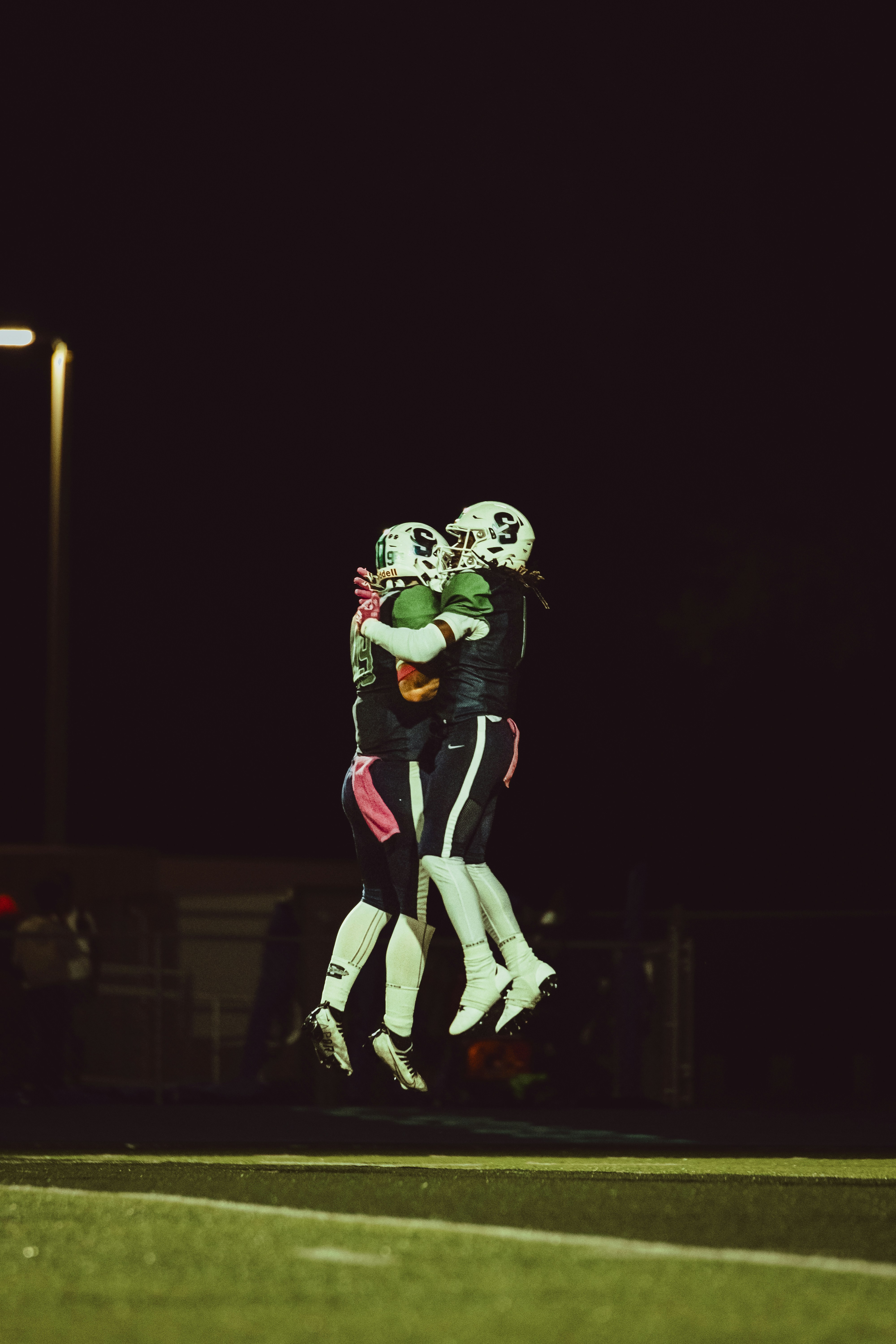 Two football players hugging each other on a field photo – Free Usa ...