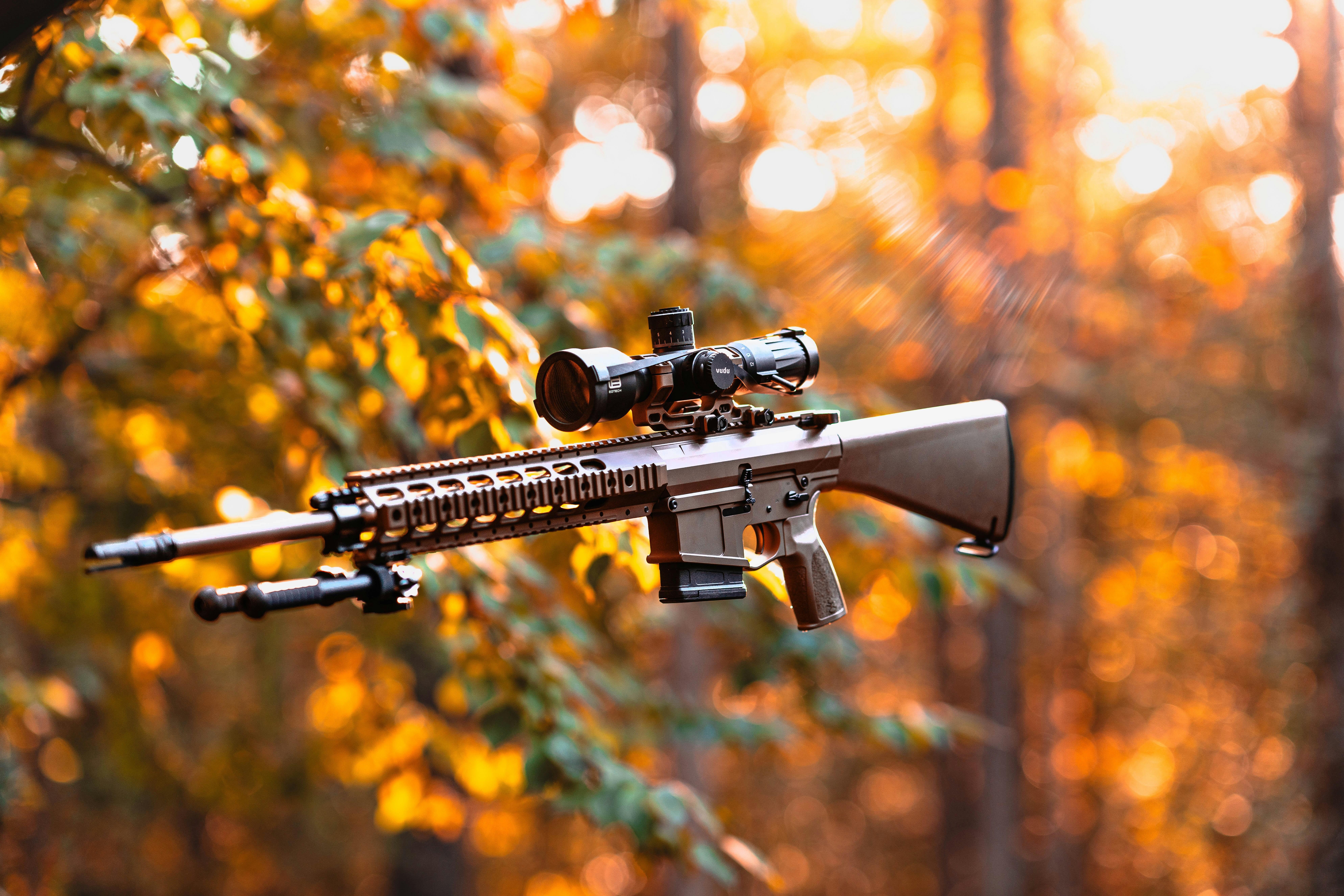 A rifle with a scope attached to it in the woods photo – Free Firearm ...