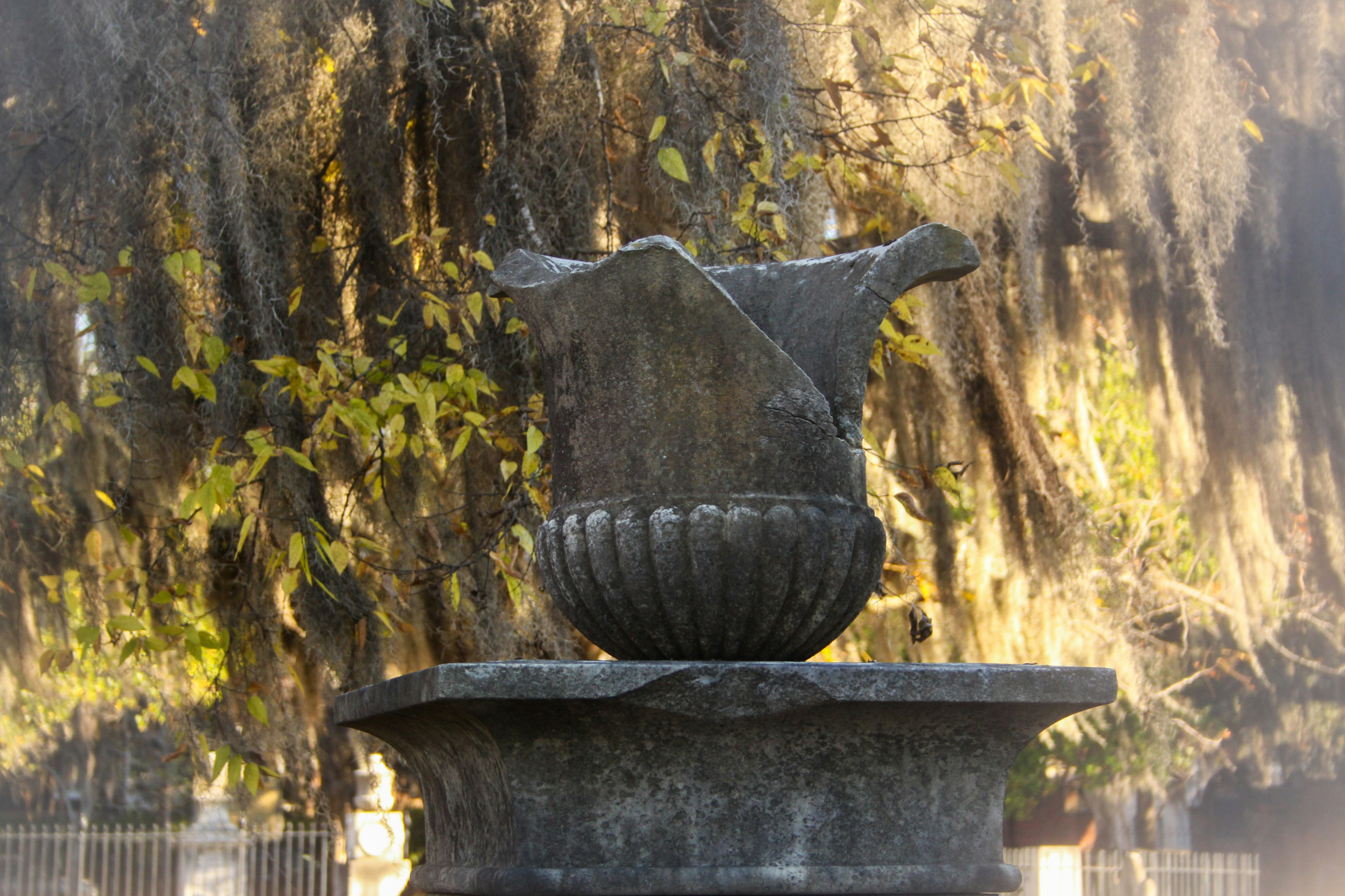Storm-Tempered Vessel: A Weathered Fountain Sculpture in Dappled Light