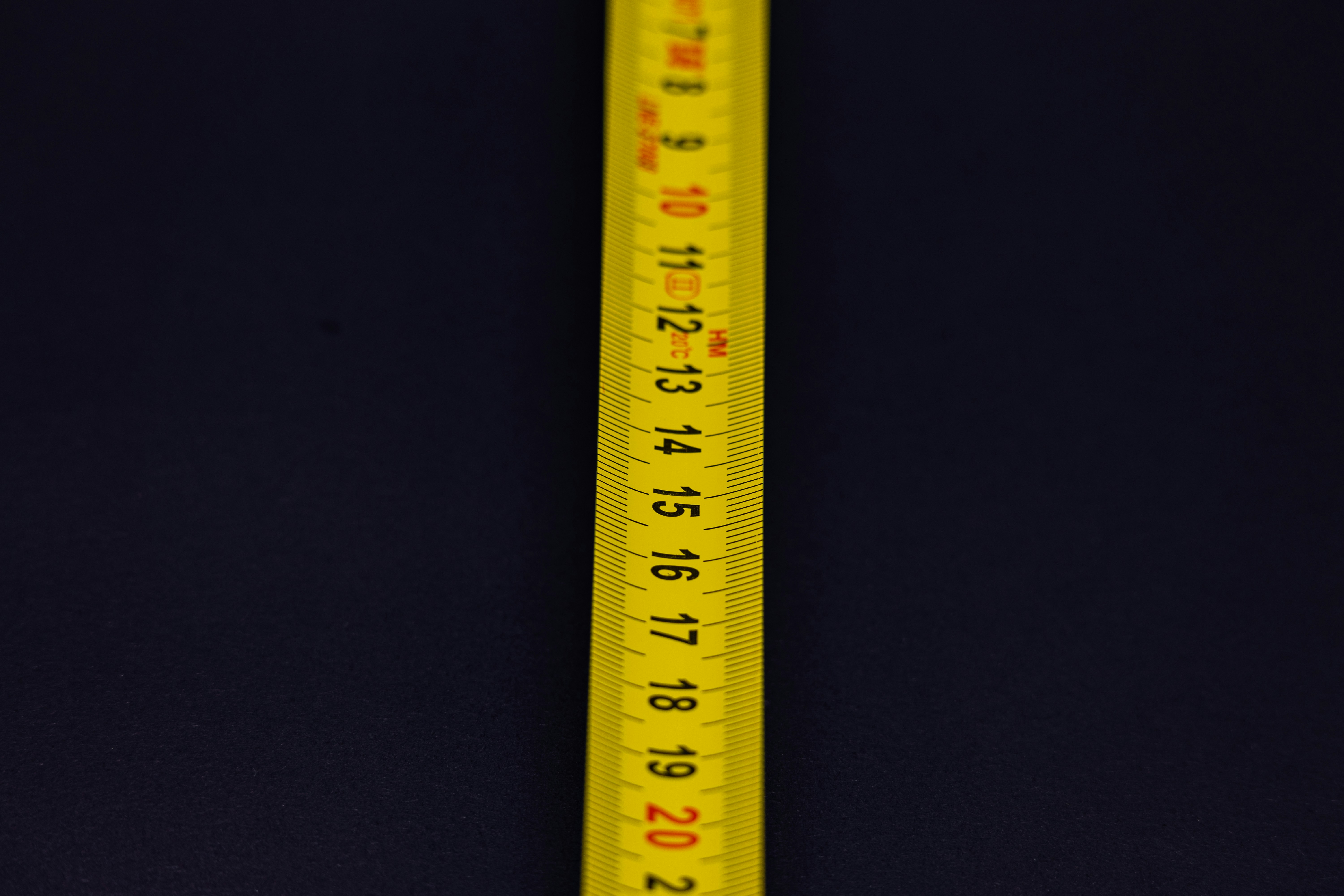 A yellow measuring tape on a black surface photo – Free Plot Image on ...