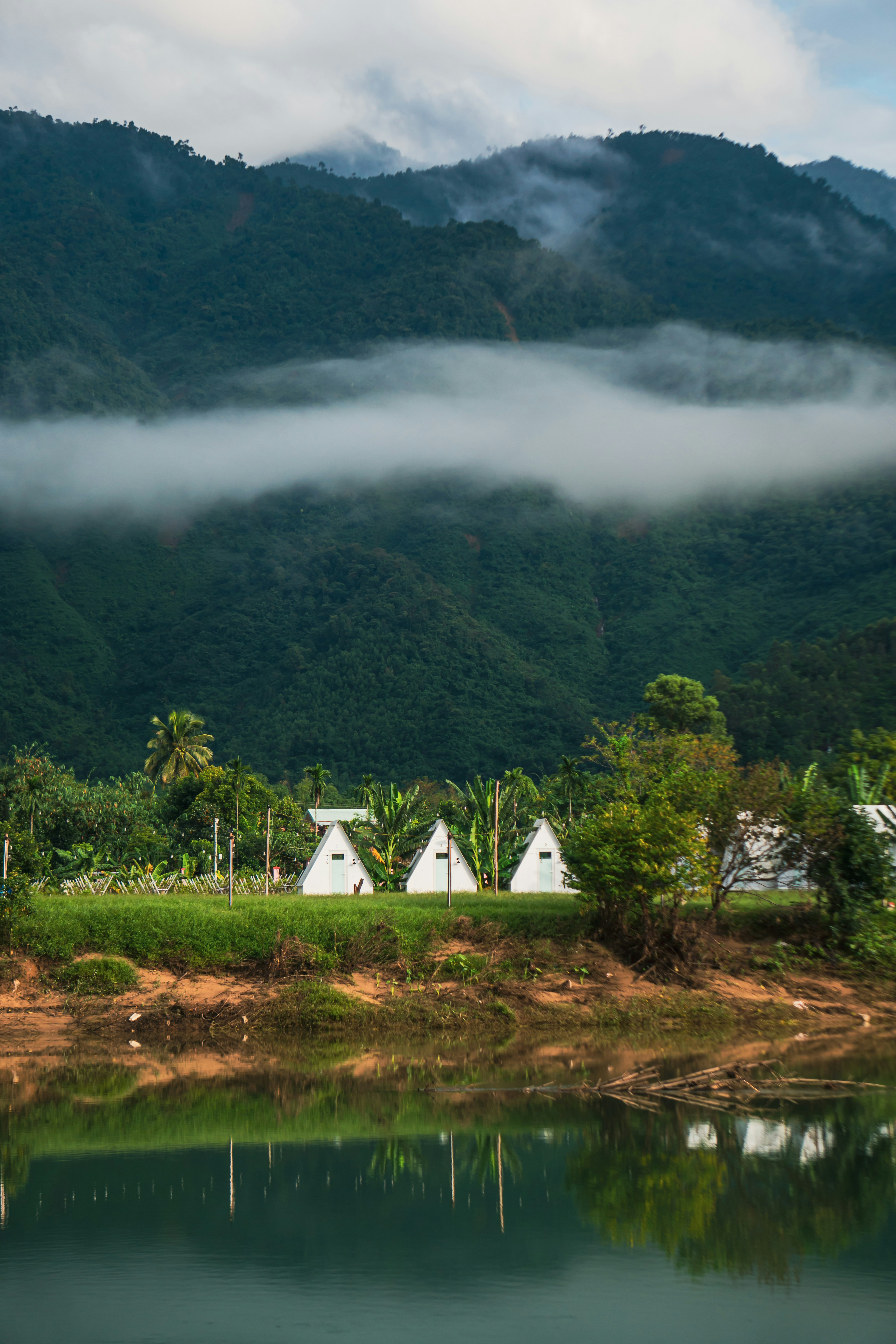 White A-Frame Homes at the Foot of Misty Green Peaks