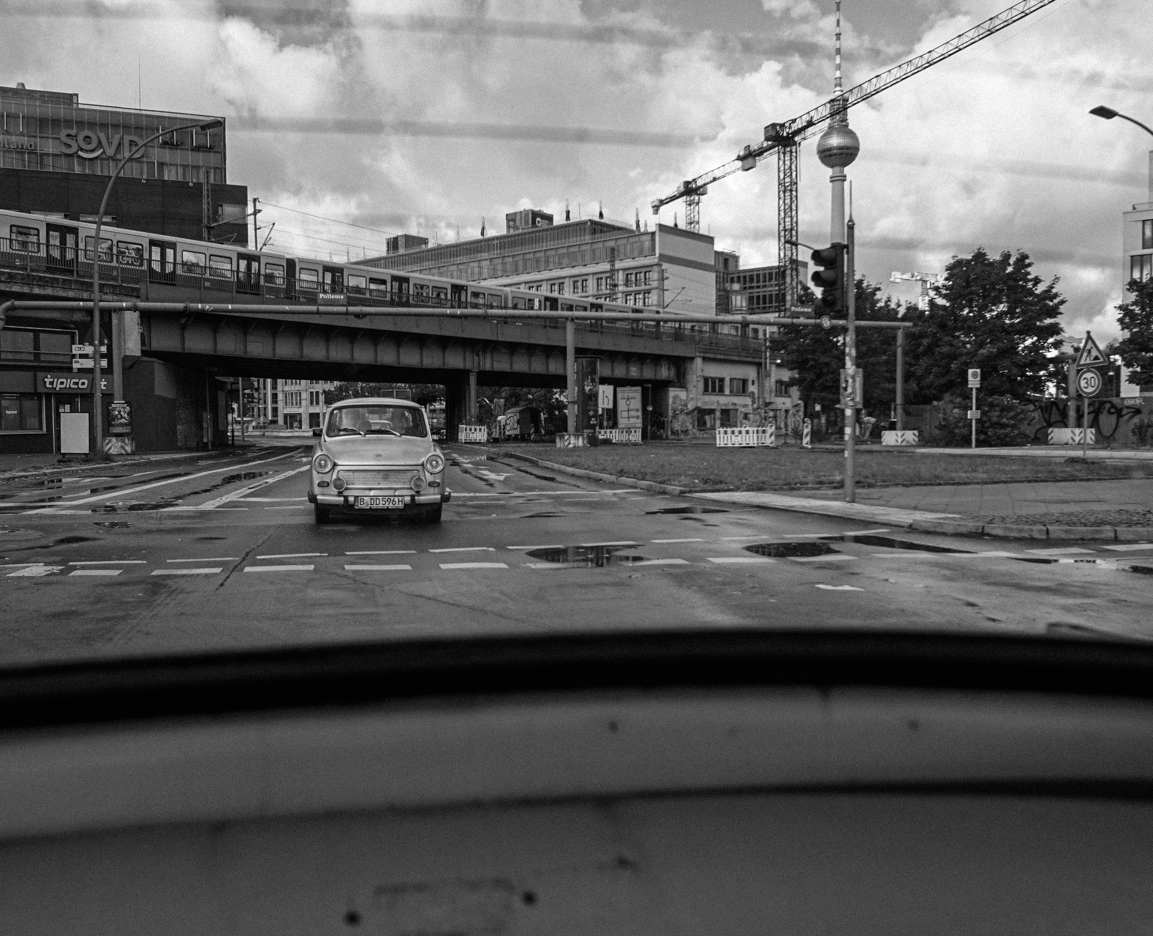 Beetle at the Crossing: A Vintage Car Beneath the Urban Rails