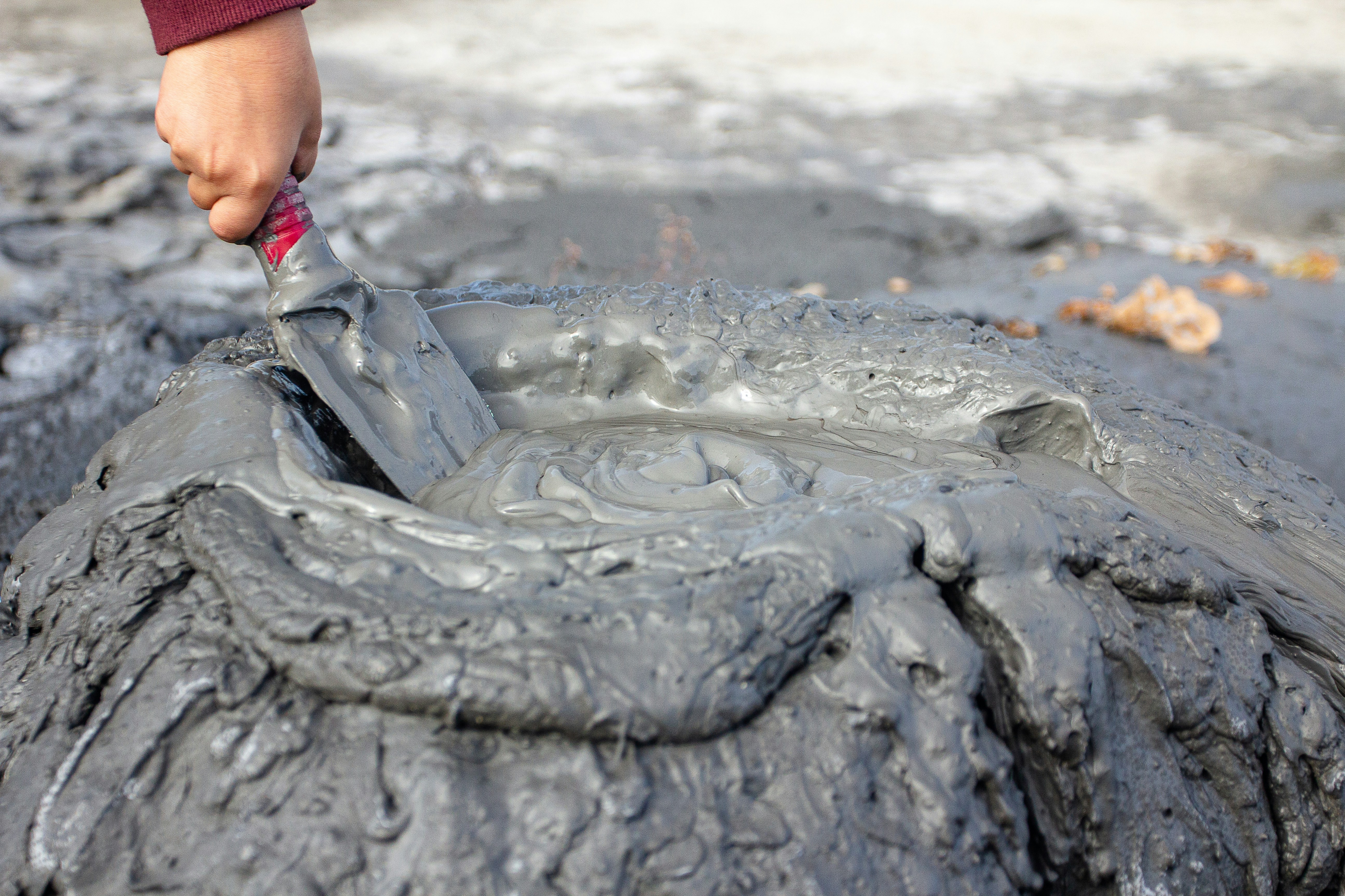 Grip of Gray: A Hand Stirring Thick Mud
