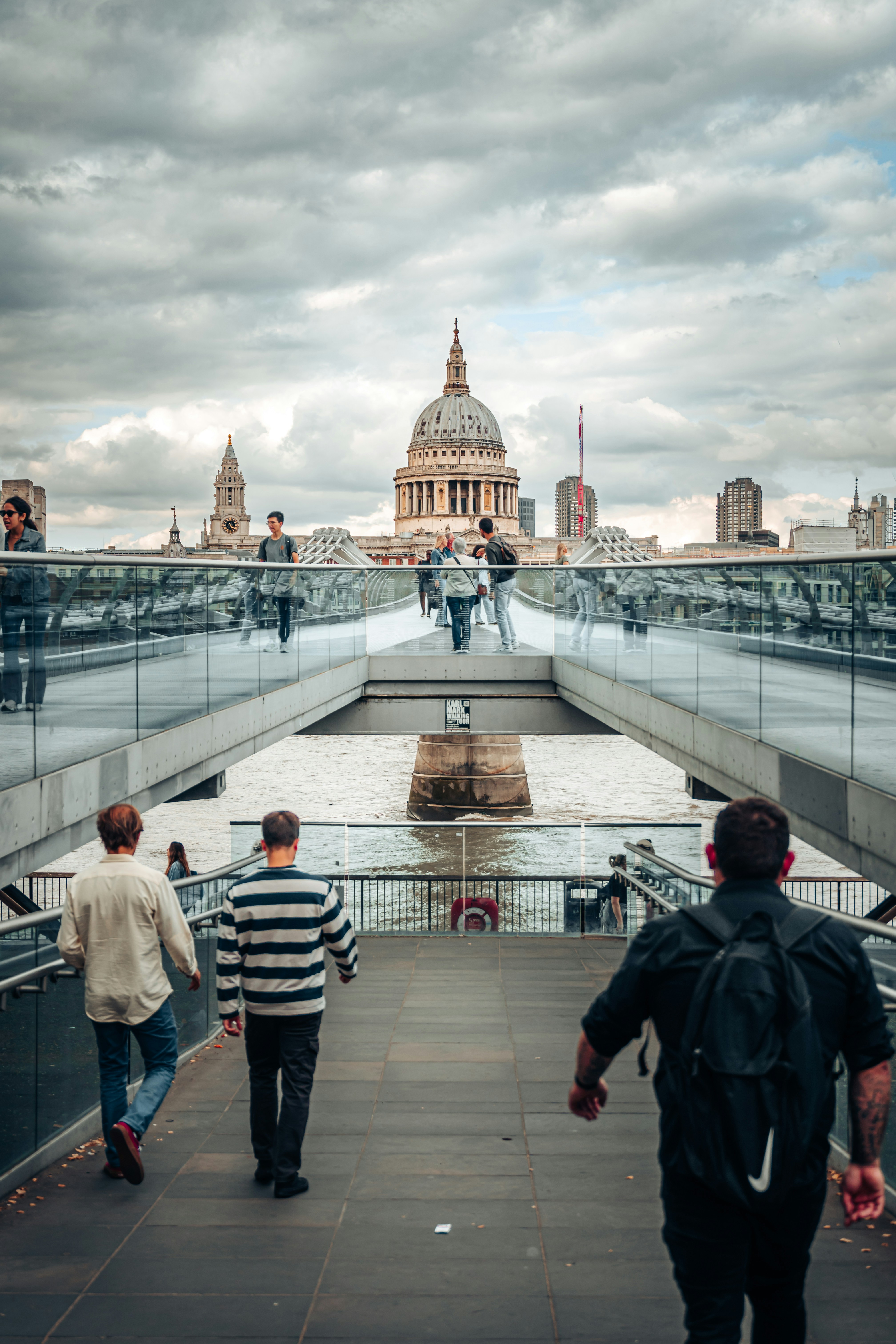 A group of people walking across a bridge photo – Free Man Image on ...